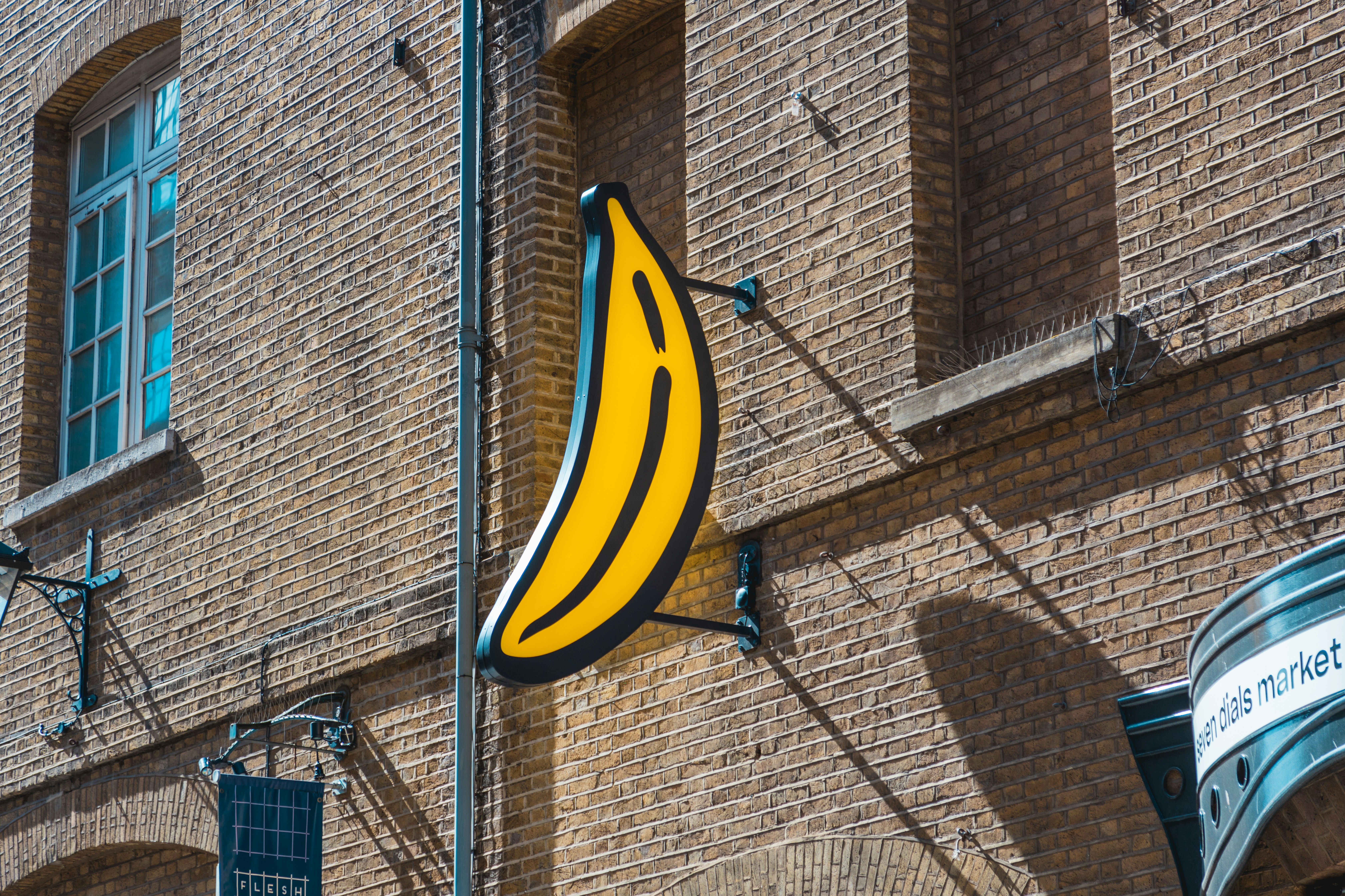 Banana Sign on Brick Facade Sparks a Street-Side Moment