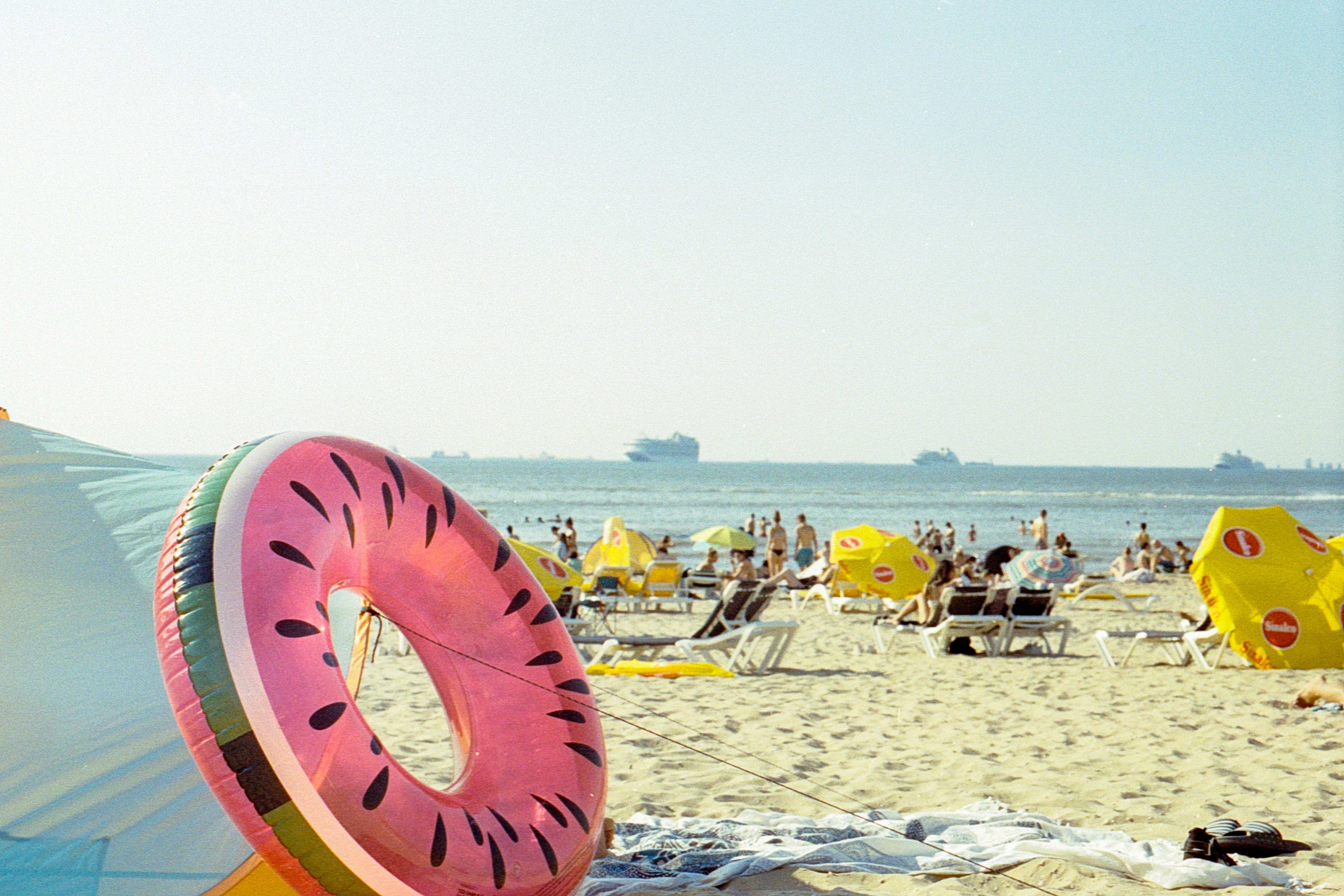 Sunlit Beach Carousel: A Lifebuoy in the Foreground, Toward a Busy Shore