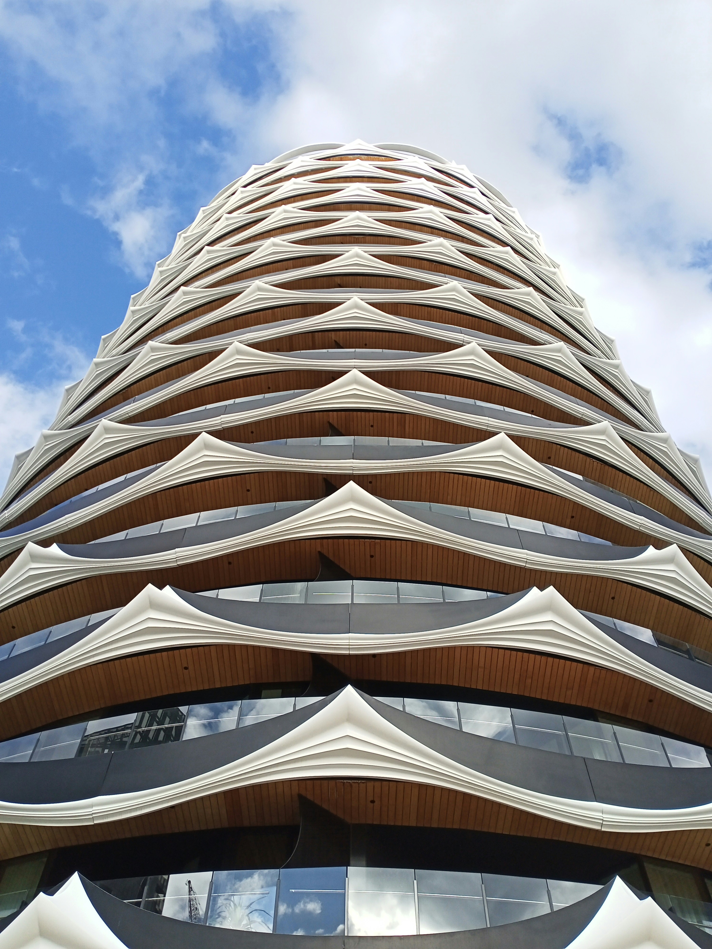 Spiraling Scallop Facade: a tower of stacked balconies reaching the sky