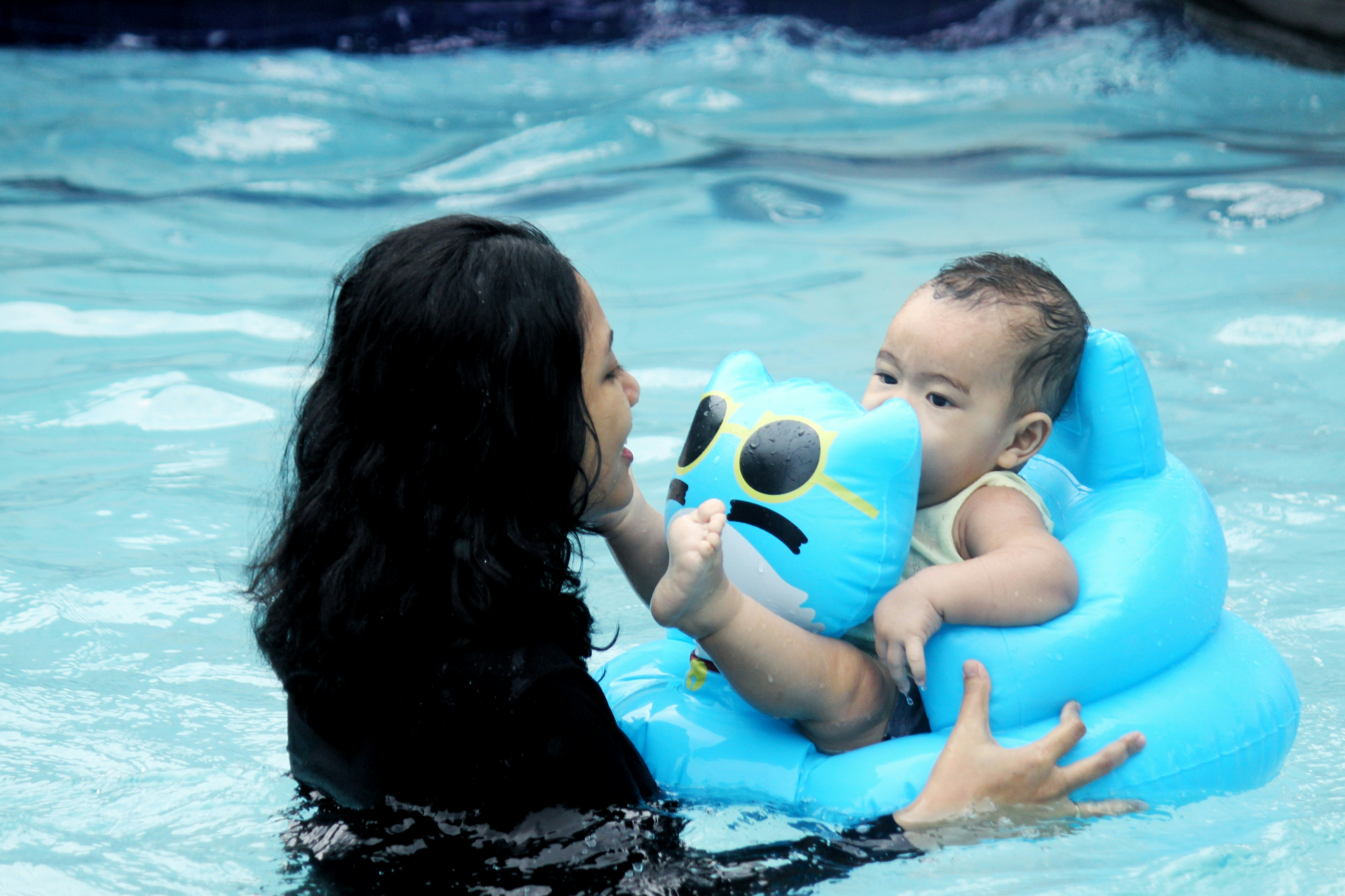 Blue-Float Moment: A Mother's Gentle Hold in the Pool
