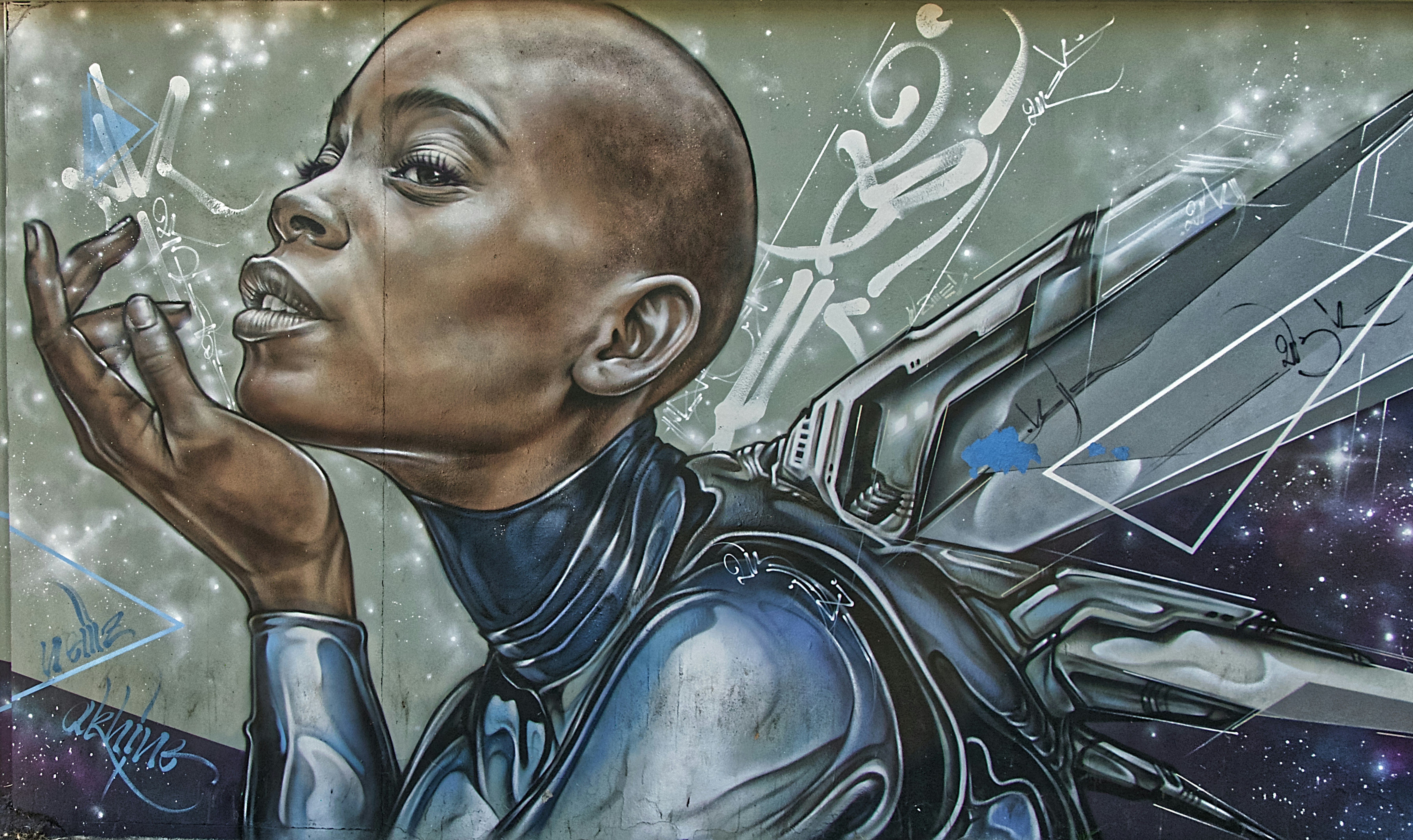 A striking mural depicting a bald woman in futuristic attire, gazing thoughtfully while surrounded by abstract patterns and cosmic elements.