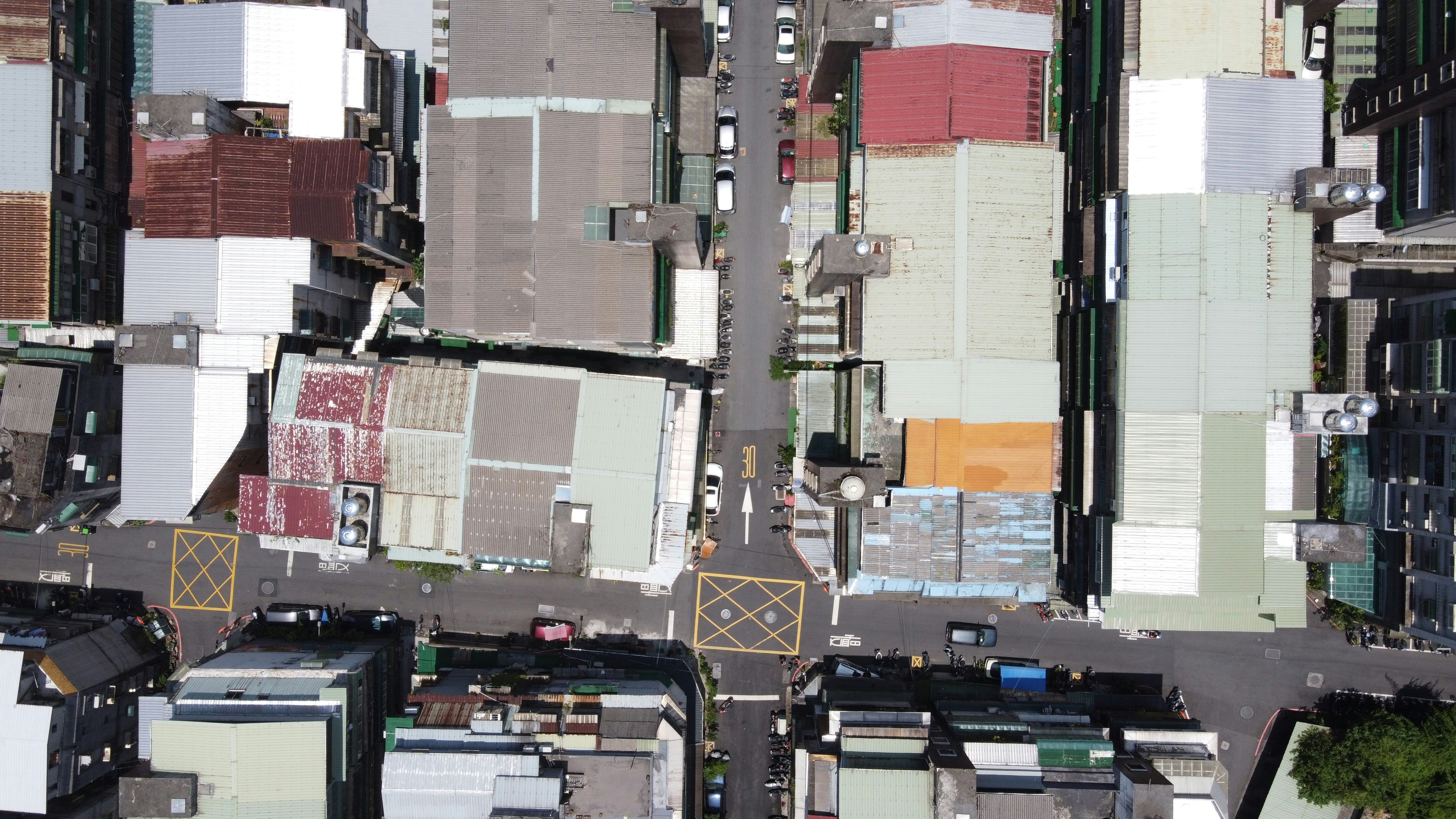 Aerial view of a bustling urban area showcasing a grid of rooftops and streets, highlighting the intricate patterns of city architecture.