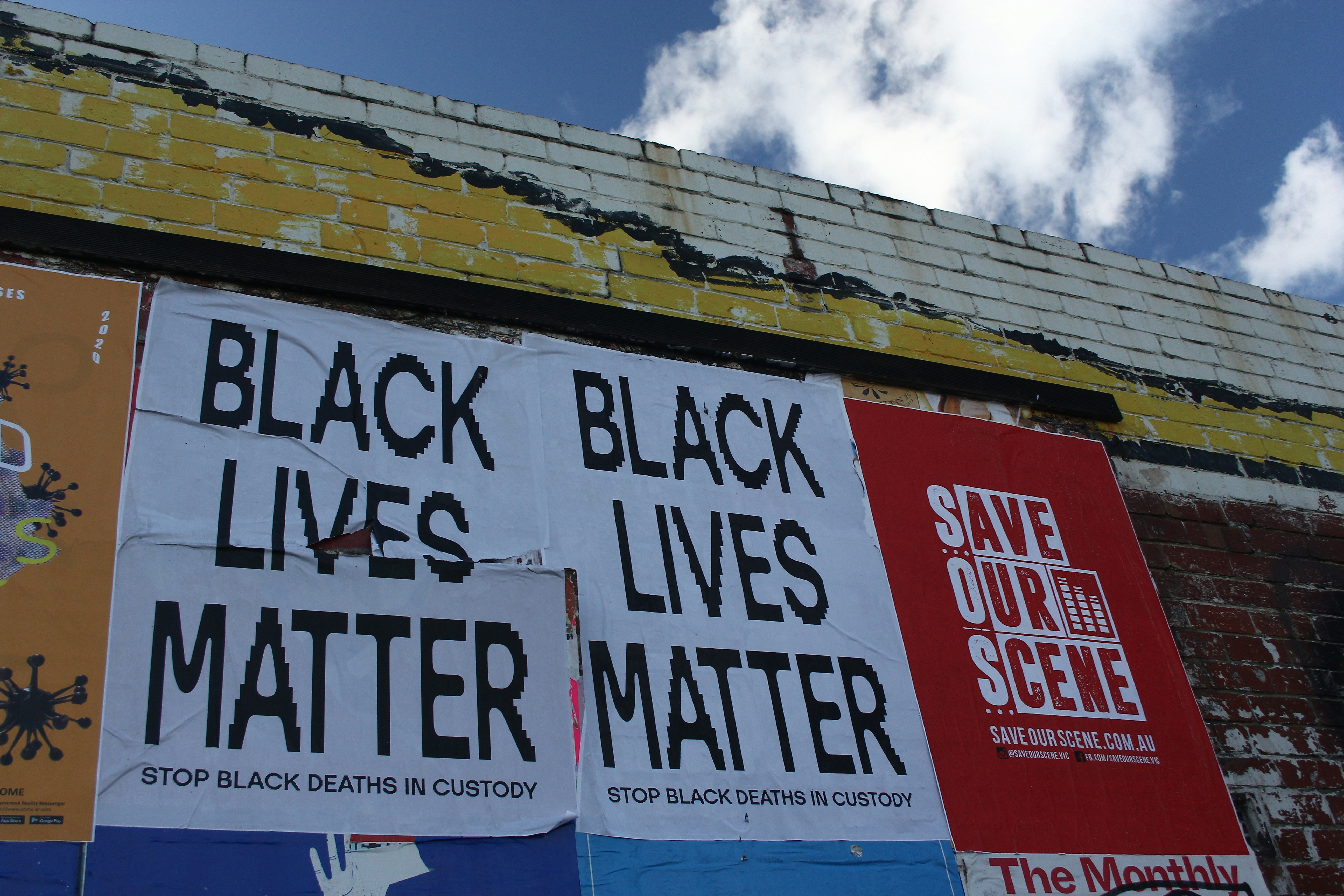 Bold posters advocating for racial justice, prominently featuring the phrase 'BLACK LIVES MATTER' against a textured urban backdrop.
