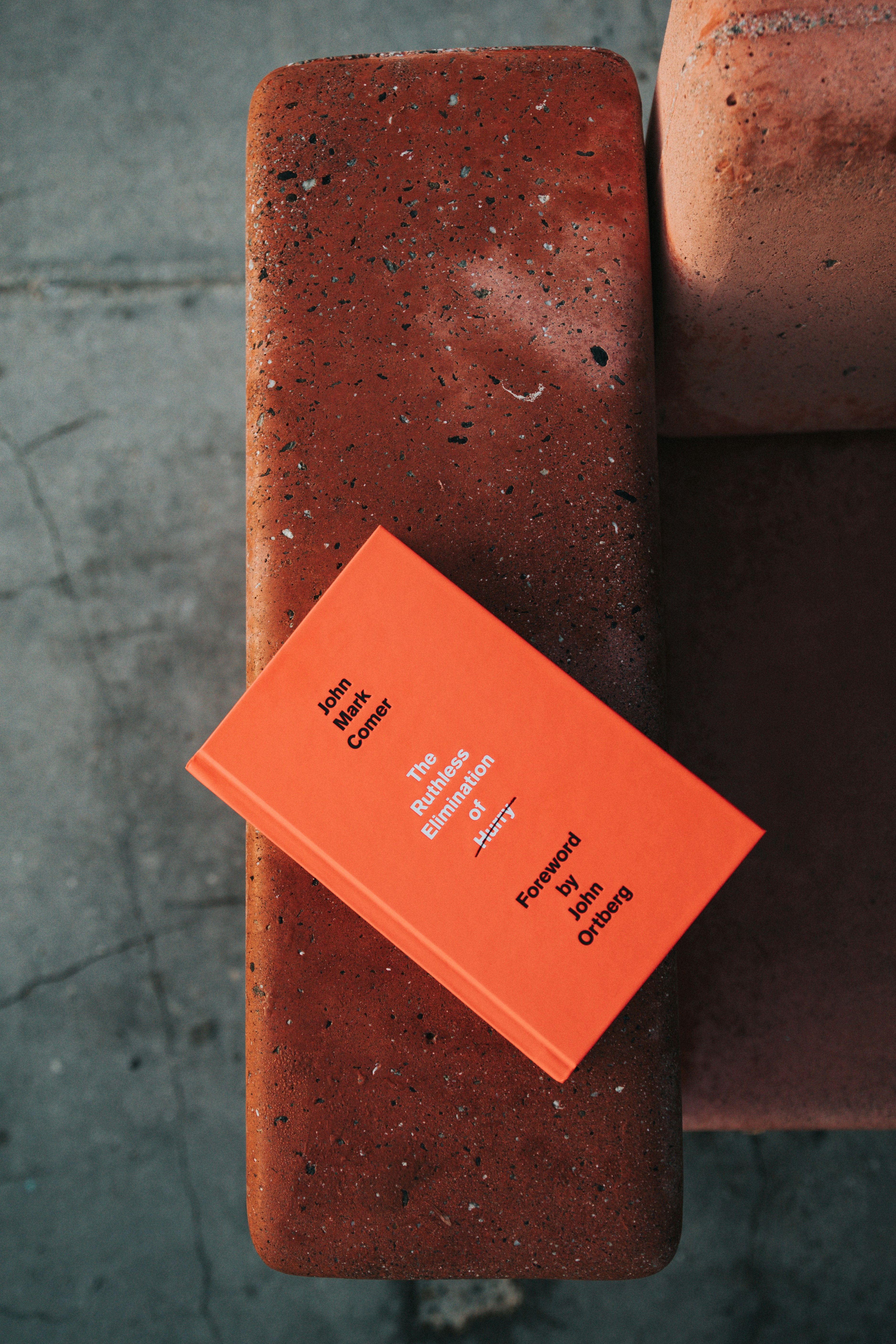 Orange Book on a Weathered Brick Seat