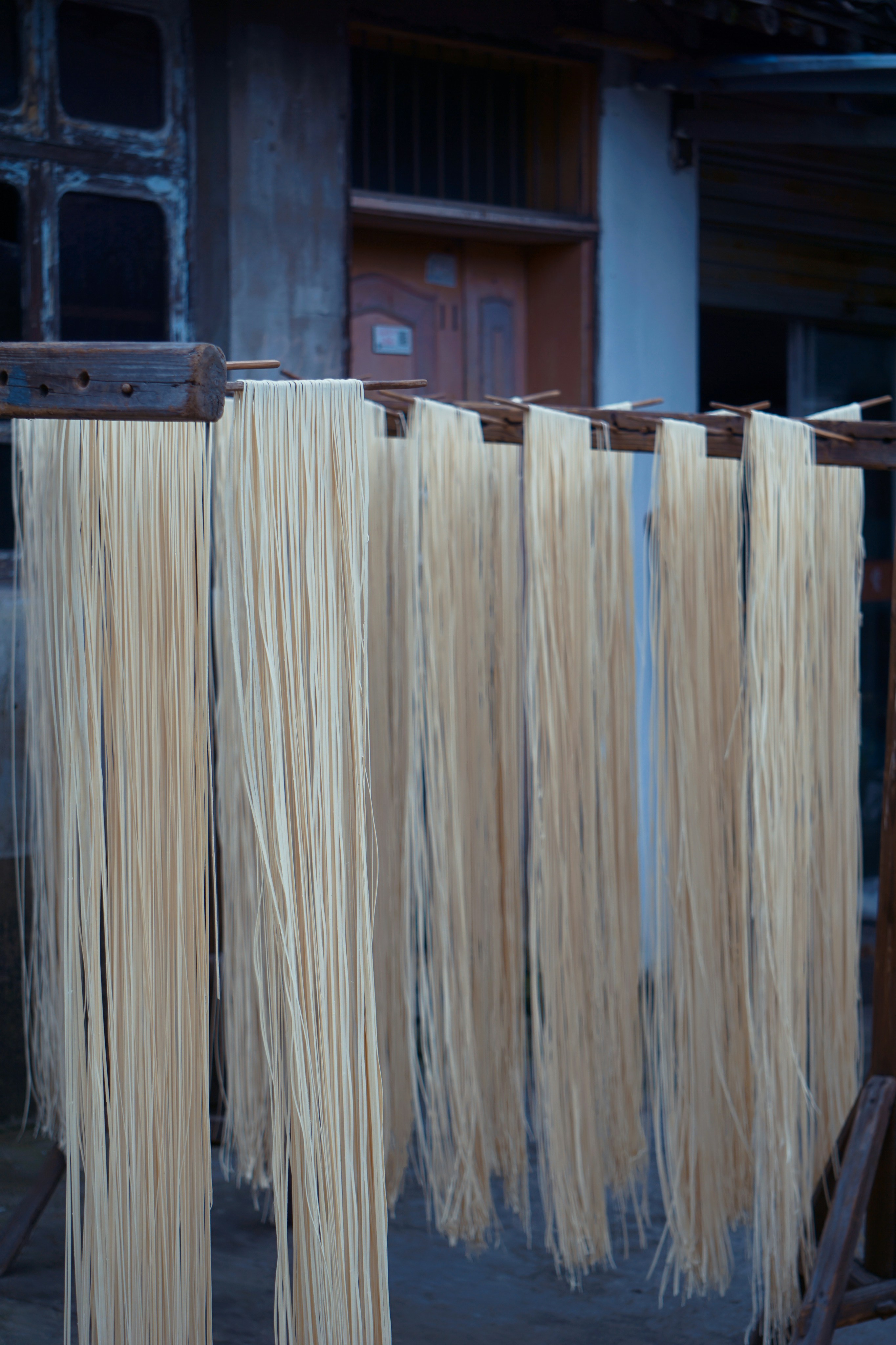 Blue Hour Threads: Noodle Lines in a Weathered Courtyard