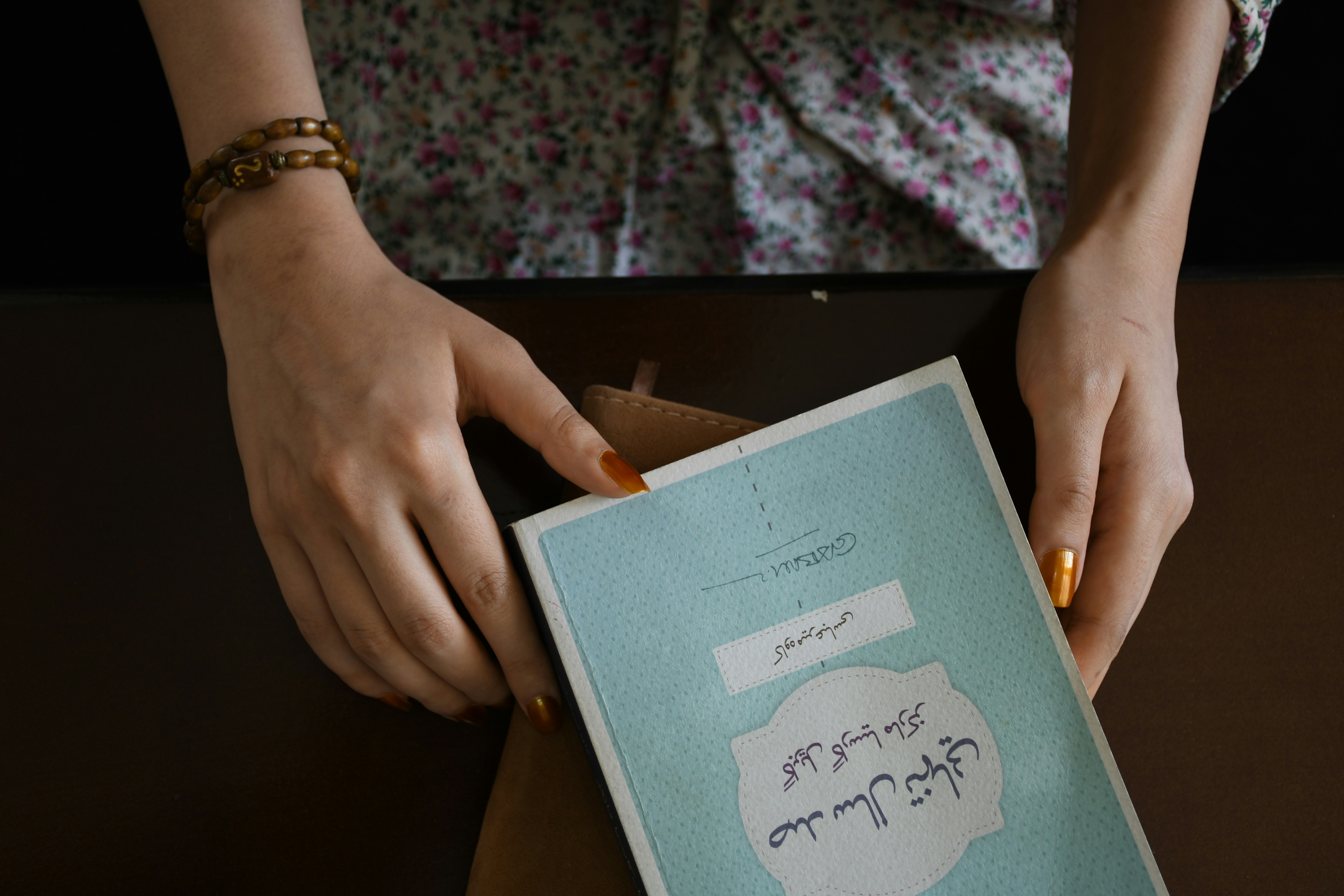 Teal-Cover Journal Cradled by Gentle Hands