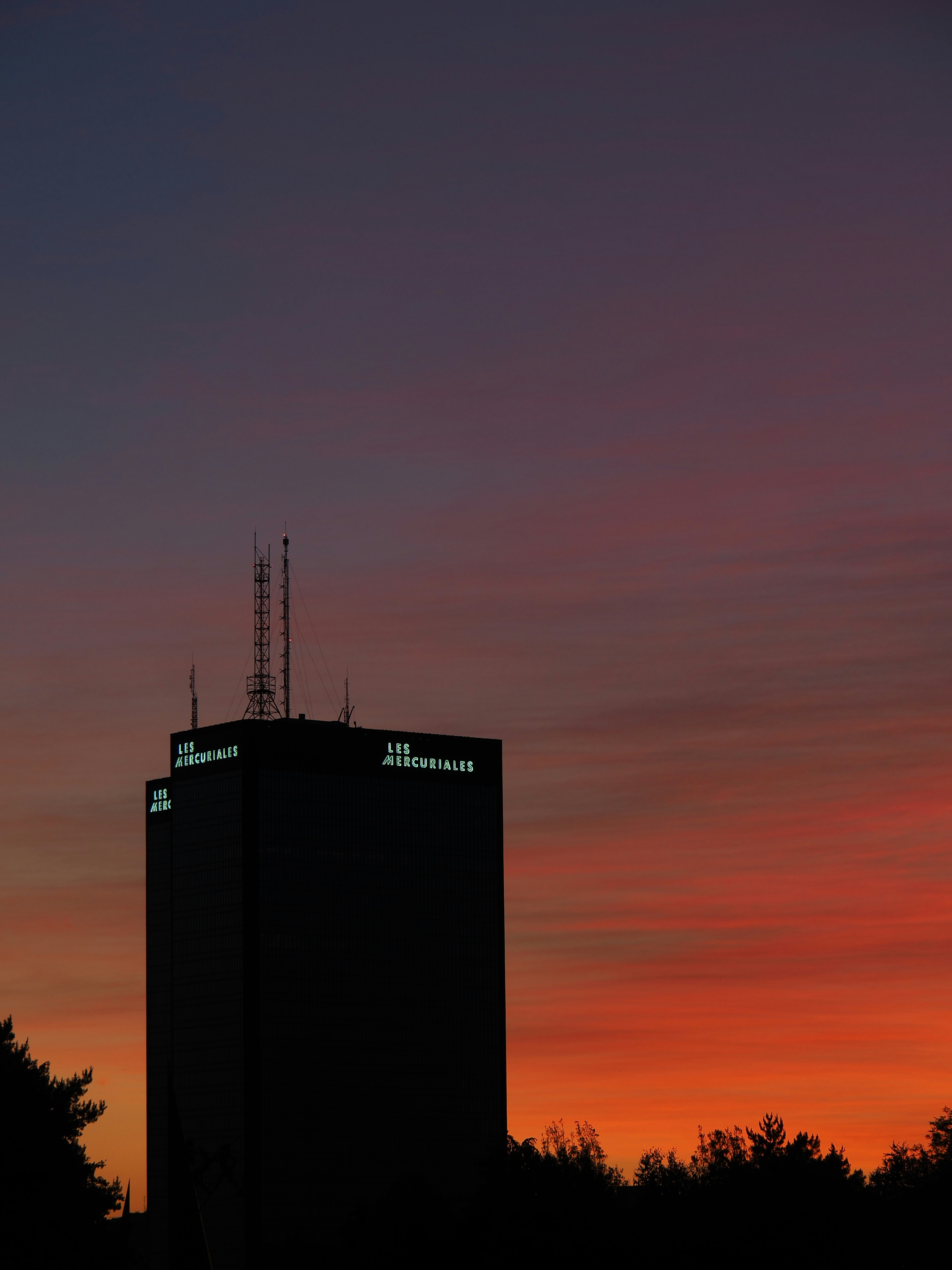 Dusk Over Les Mercuriales: Tower Silhouettes Against a Fiery Horizon