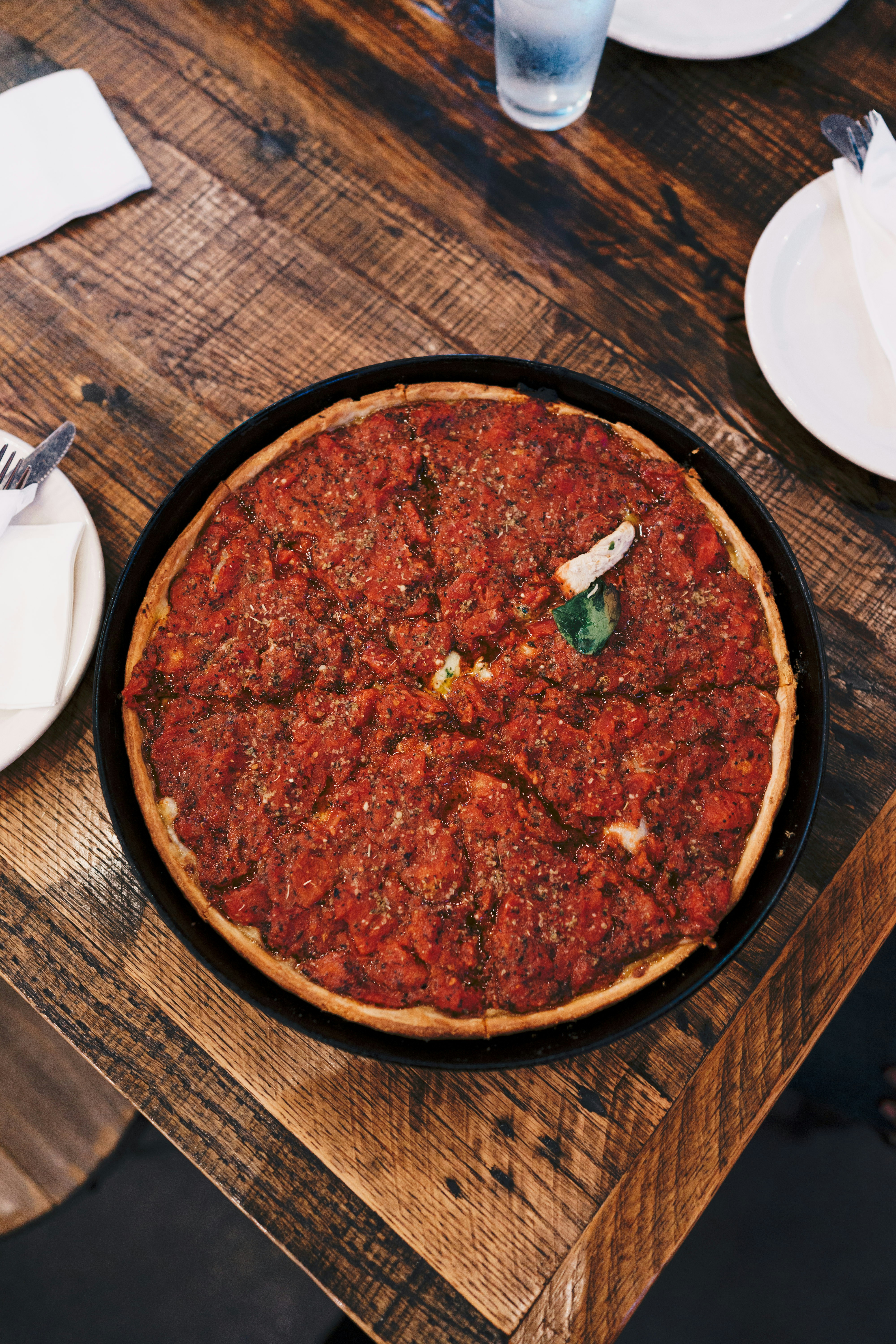 Above the Crust: Rustic Tomato Pizza on Weathered Wood