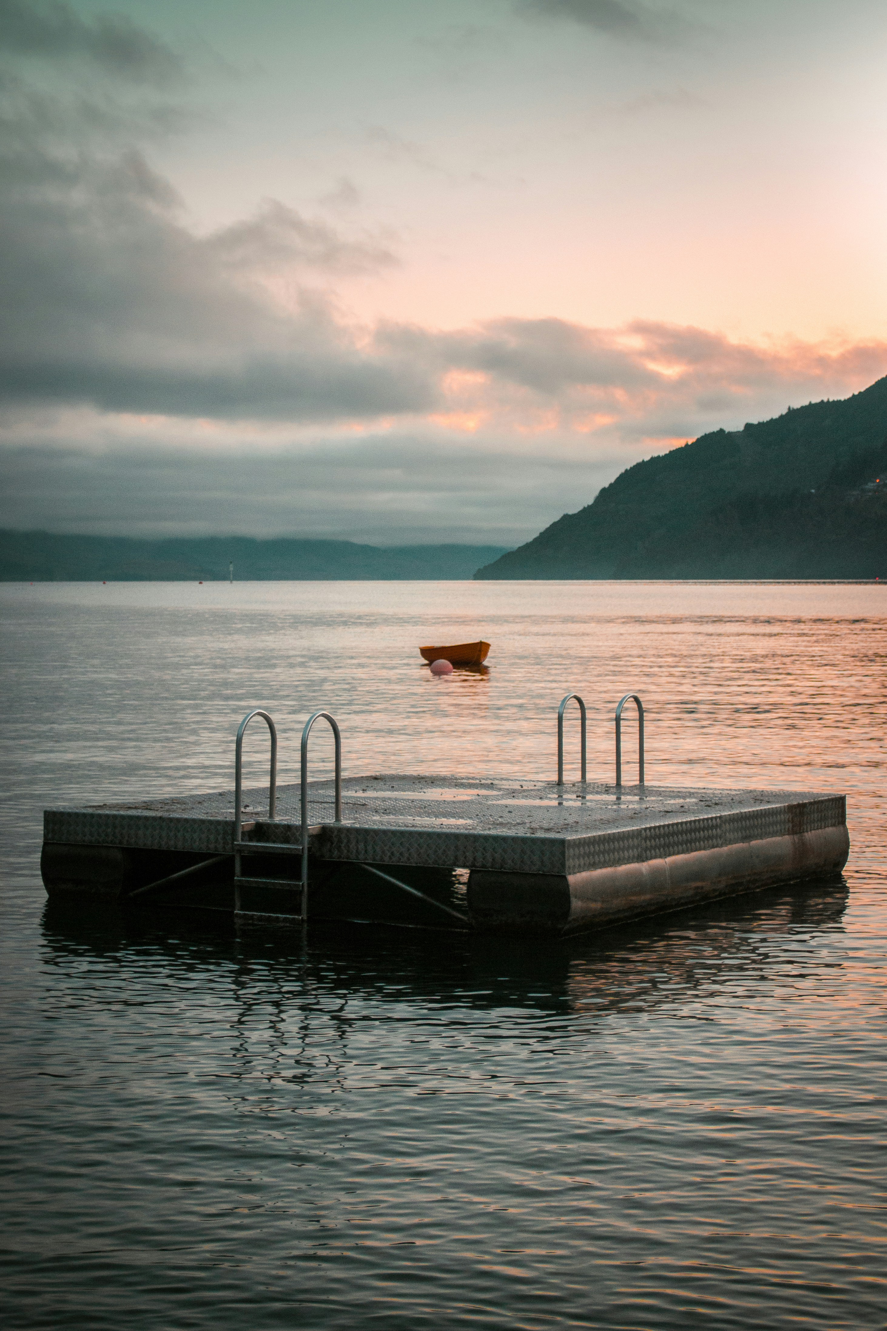Dusk over a Floating Dock: An Isolated Orange Boat on Velvet Lake