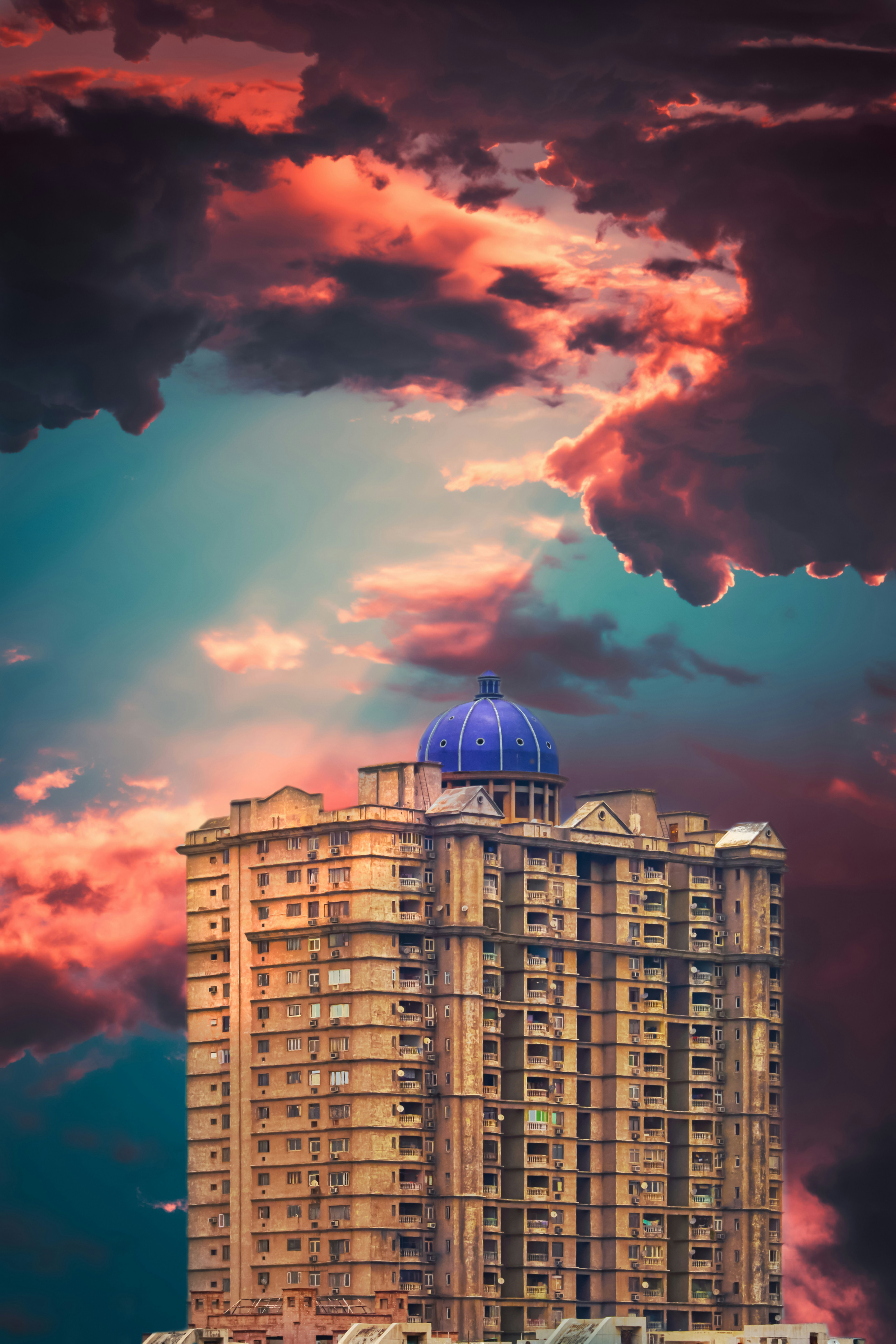 Blue Dome on a Concrete Colossus Against a Fiery Twilight Sky