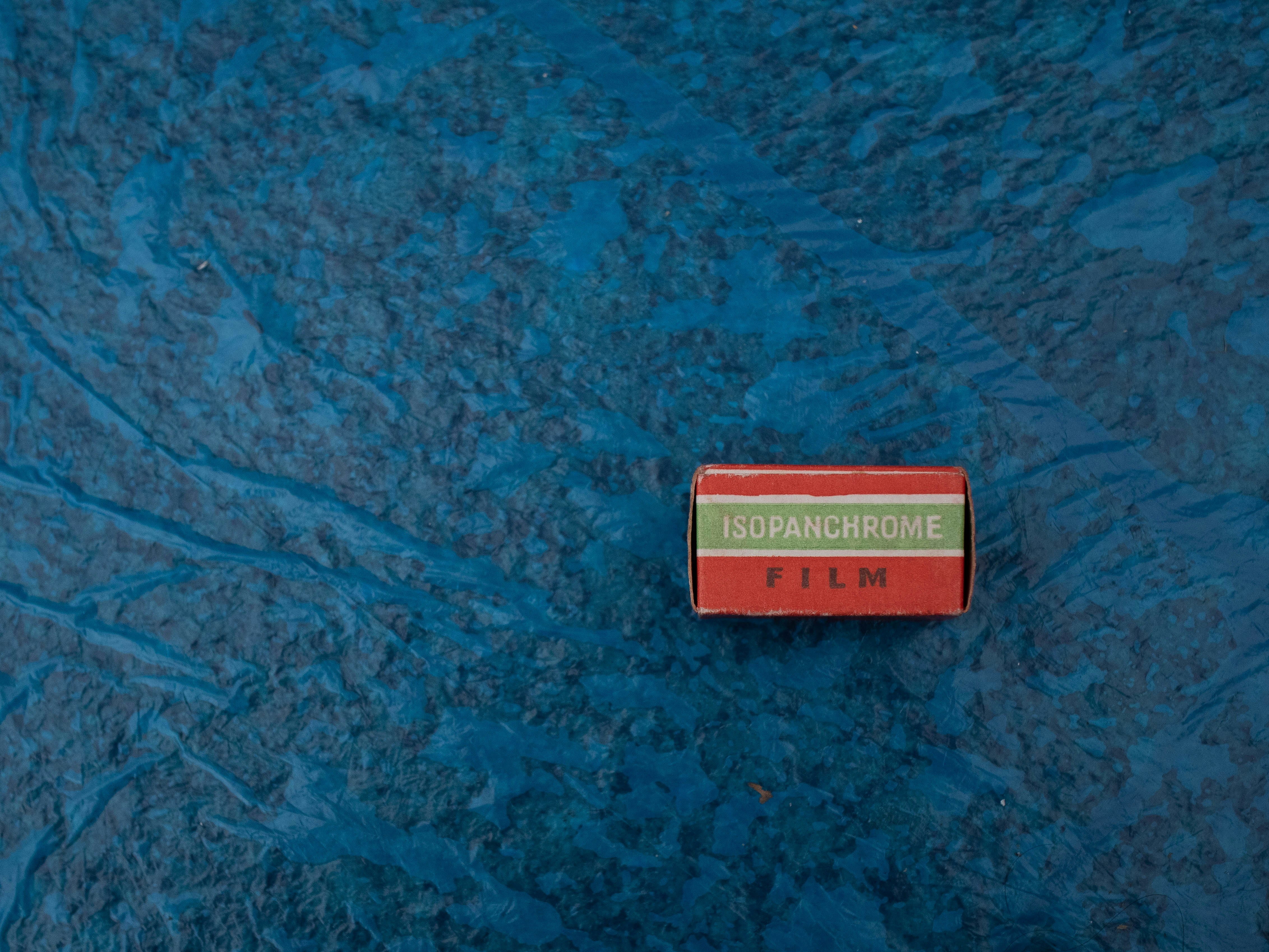 Tiny Red Film Canister on a Deep Cyan Surface