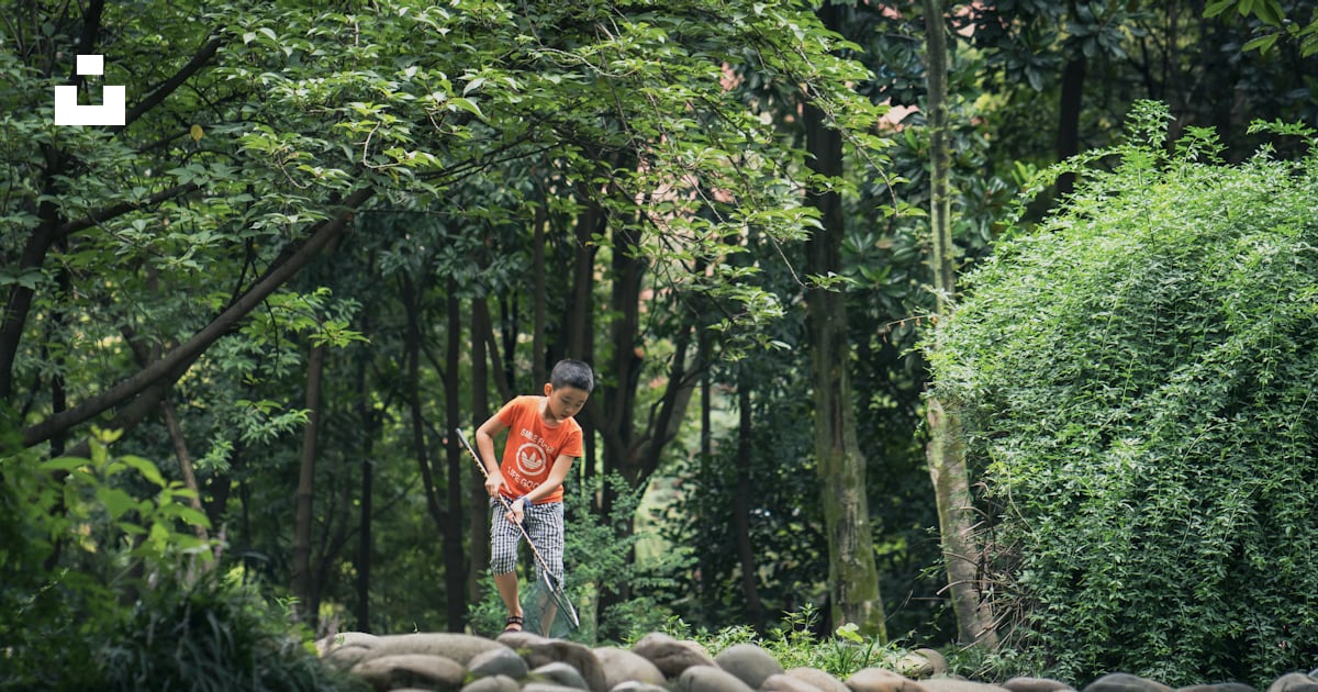 Homme En T Shirt Orange Et Jeans En Denim Bleu Debout Sur Des Rochers