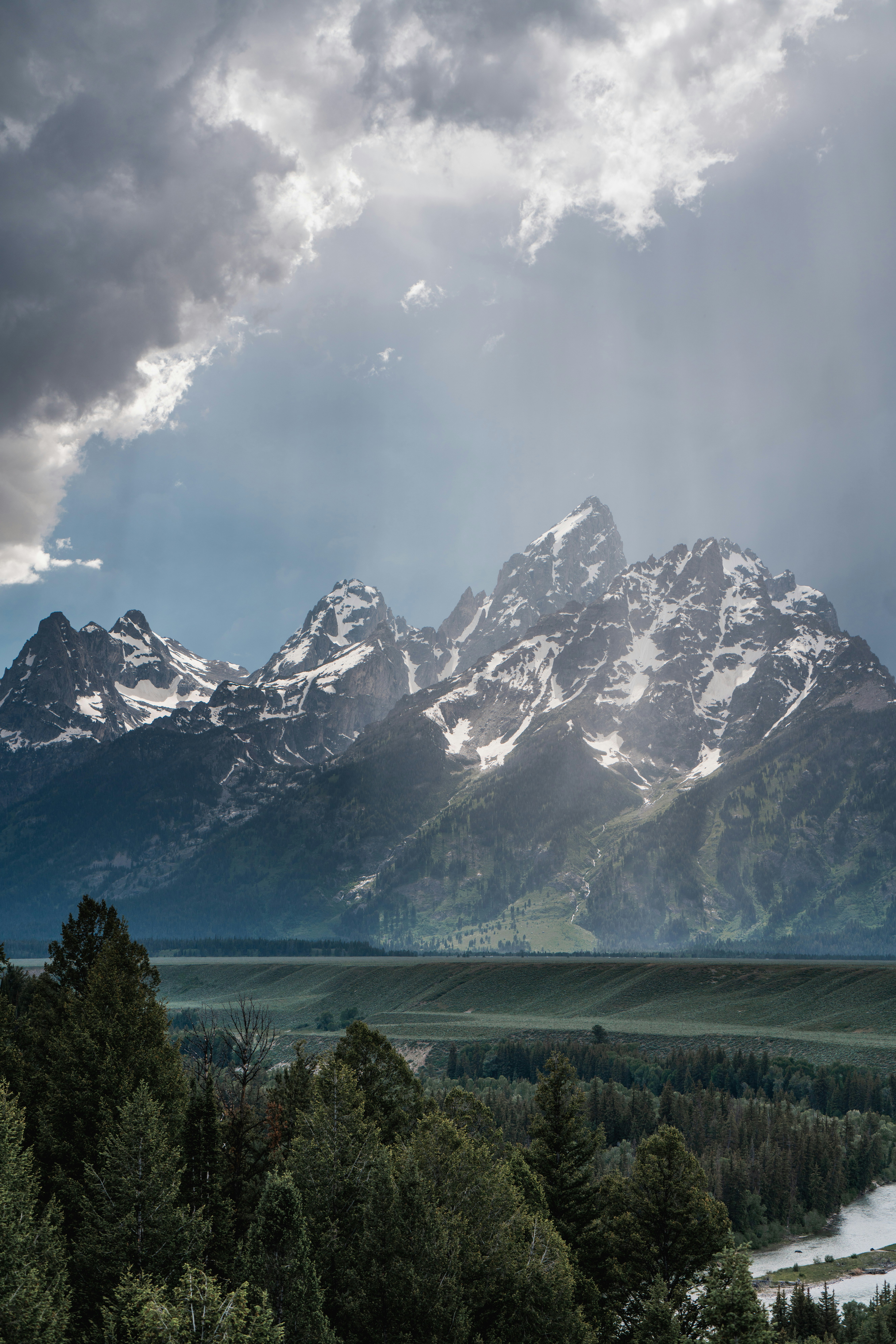 Sunbeams over a Snow-Capped Ridge and Verdant Valley