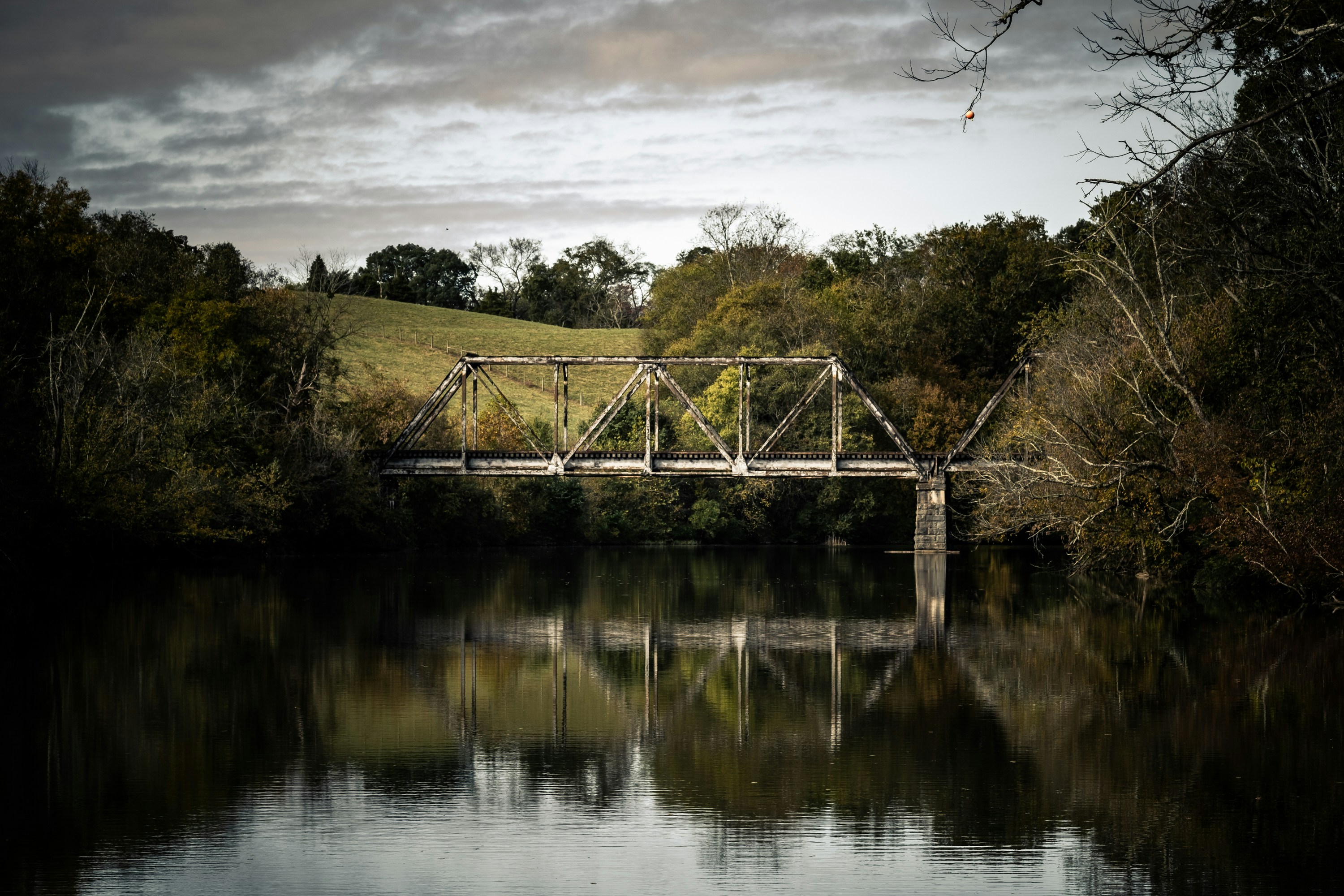 Weathered Timber Truss Bridge Quietly Crossing a Glassy Autumn River