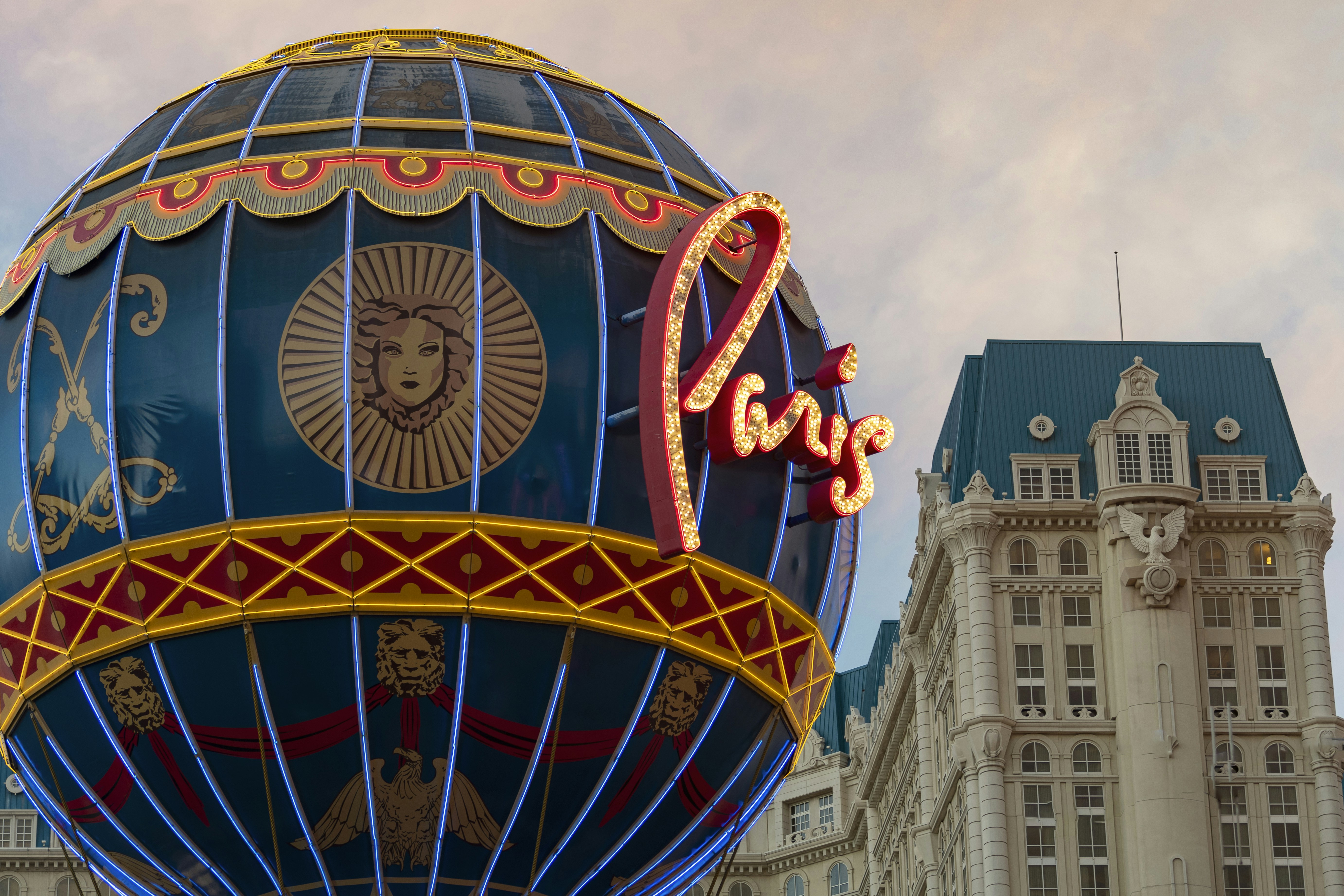 Sun-faced Balloon Meets Neon Paris Sign Over a Belle Époque Facade