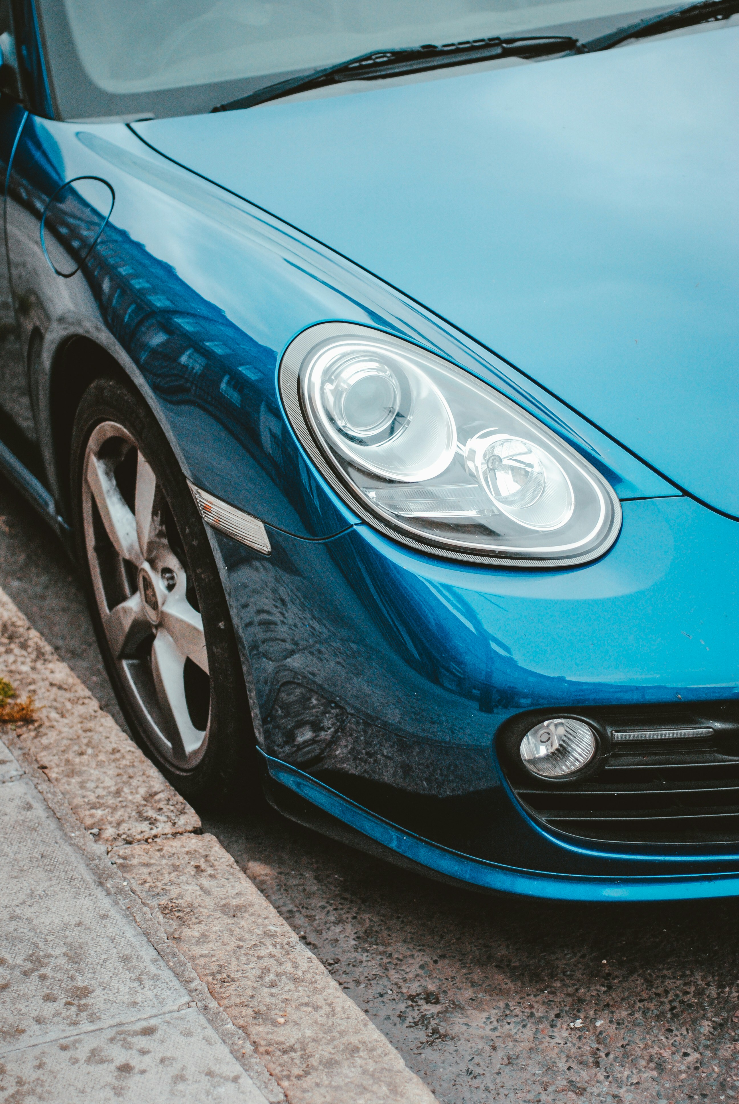 Close-up of a sleek blue sports car showcasing its polished curves and modern design elements.