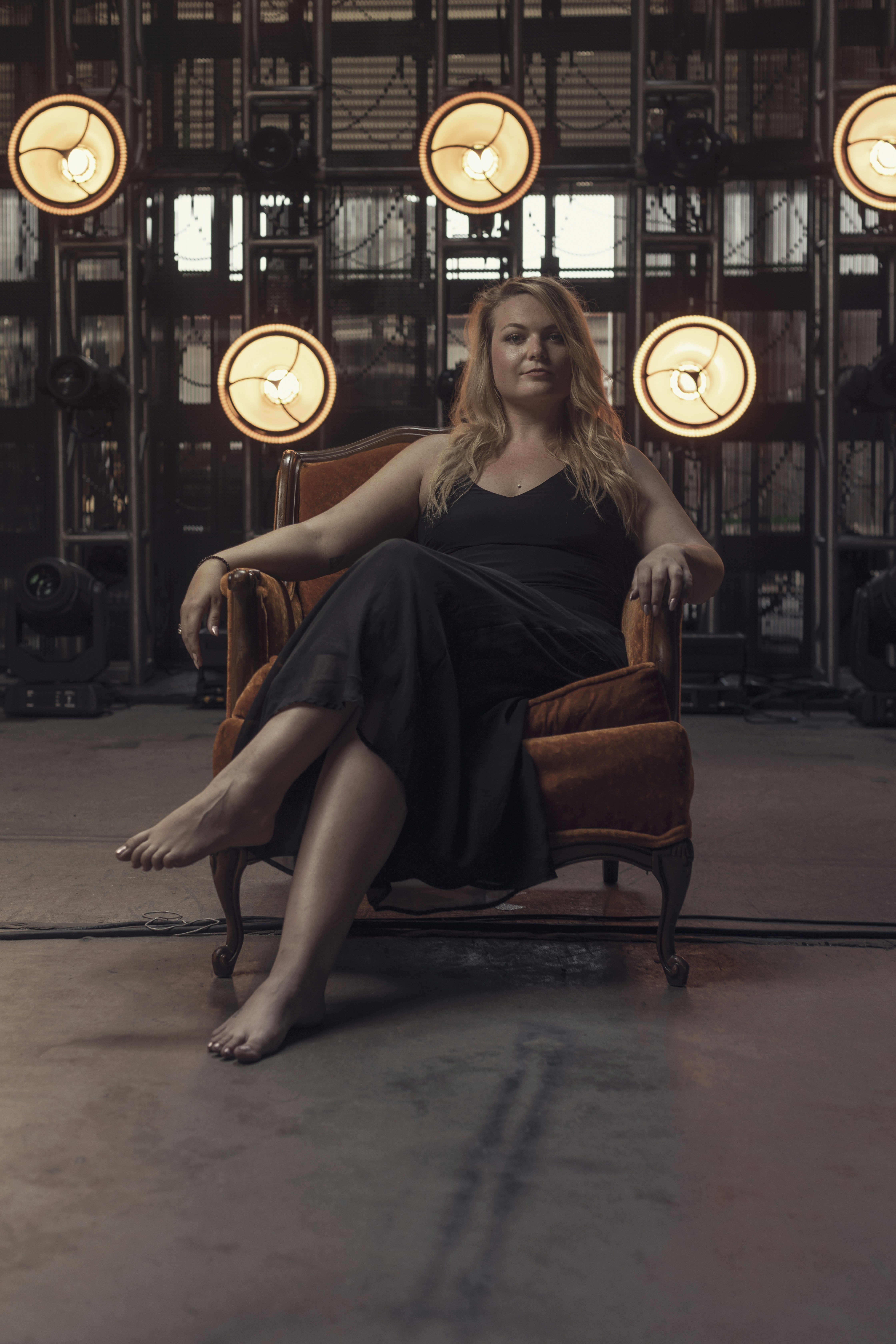 Chairbound Confidence: A Studio Queen in Front of Backlit Orbs