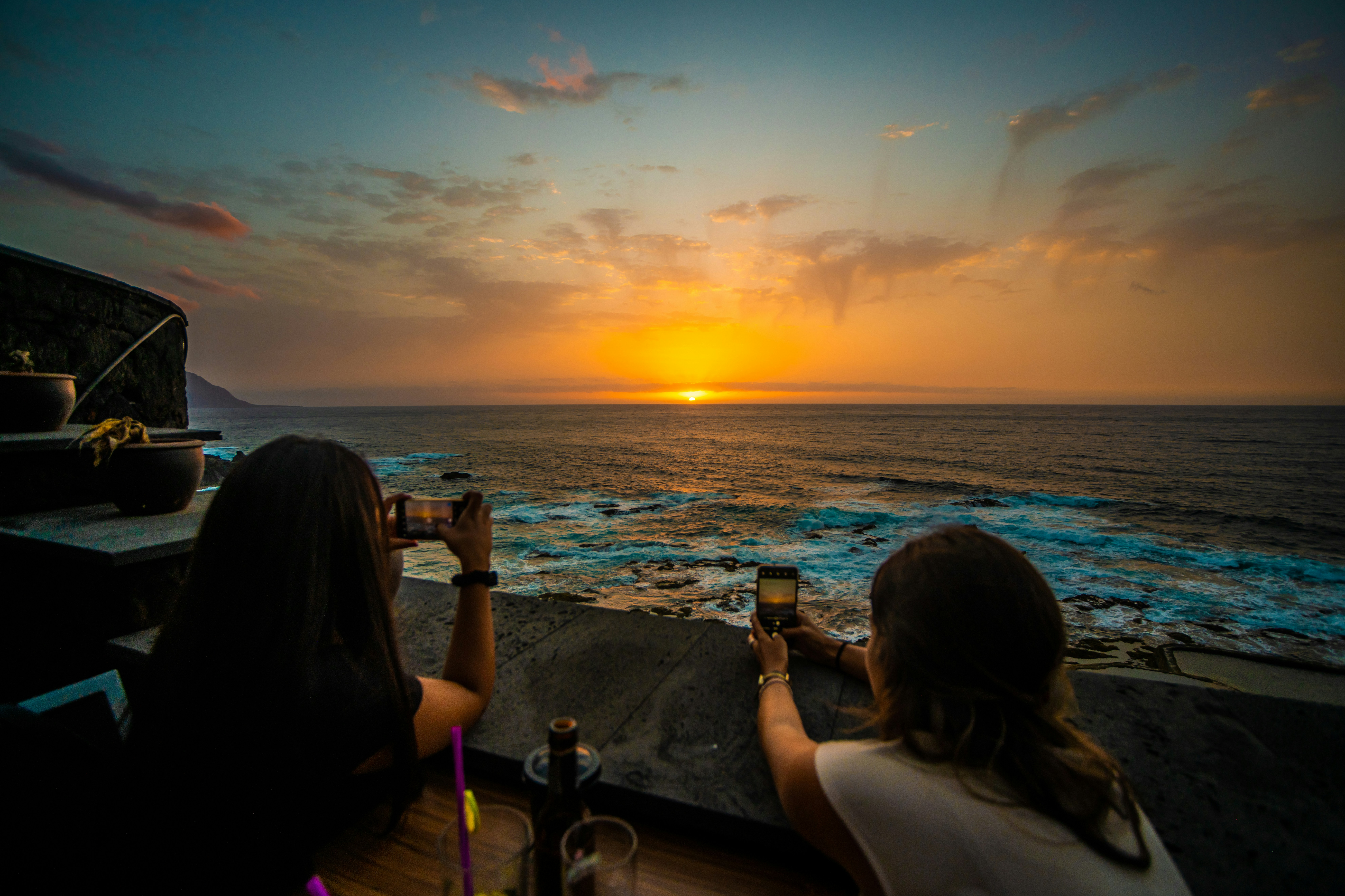 Sunset Toast: Friends Capture the Golden Hour by the Cliff