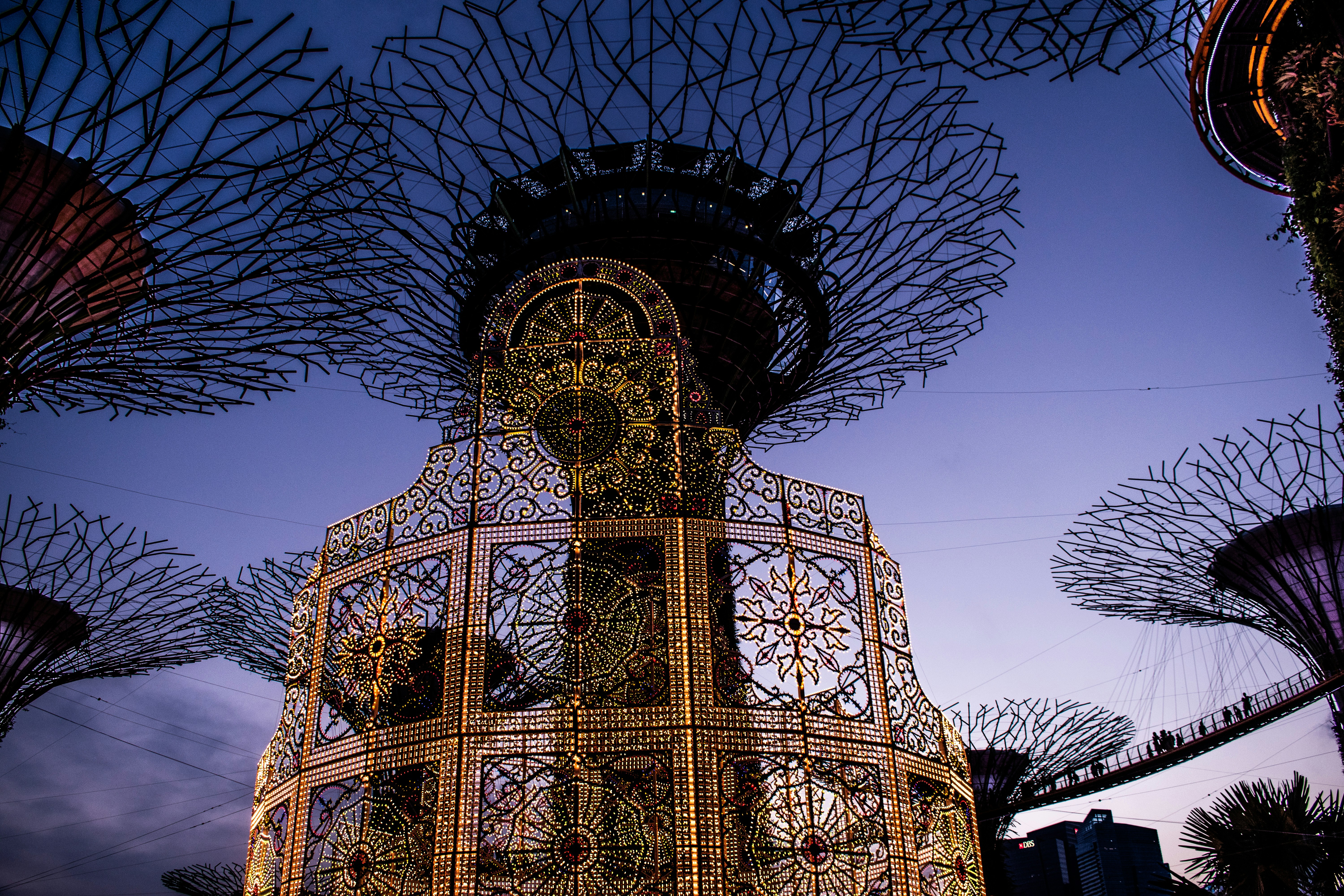 Geometric Lantern Tower Beneath a Forest of Steel Trees at Dusk