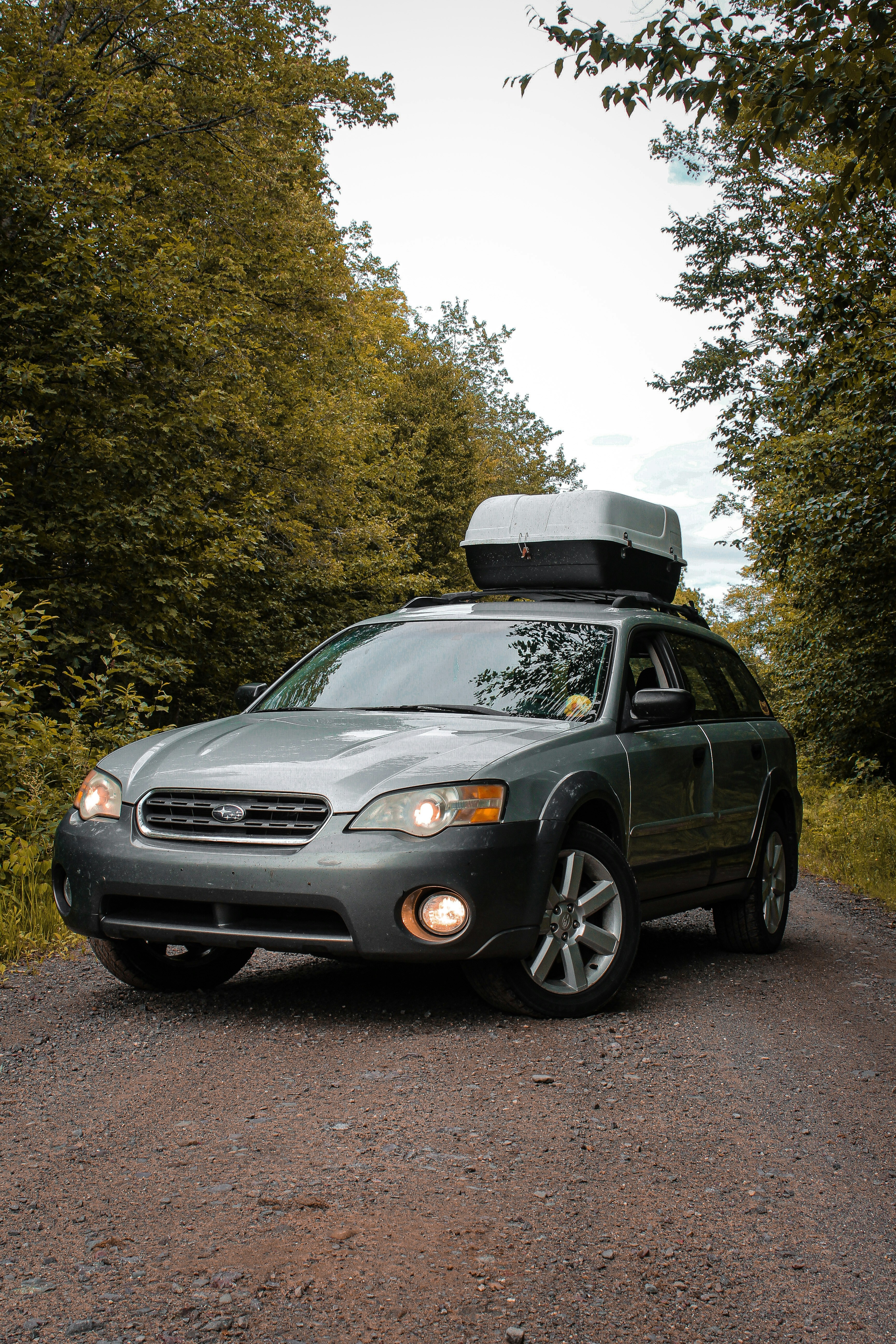 Autumn Gravel: Grey Subaru Outback Rests on a Leaf-Lined Forest Road