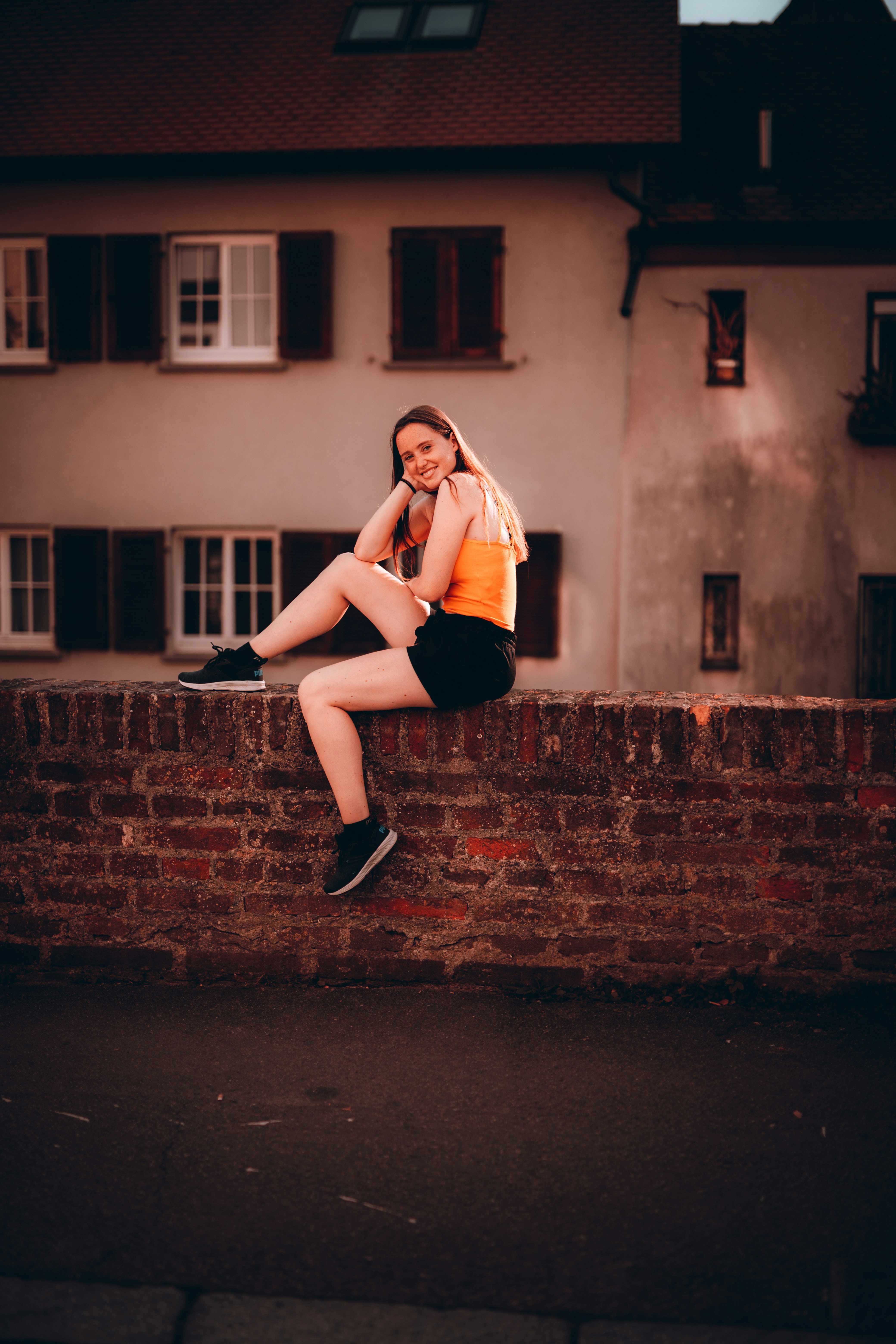 Brick Wall Reverie: The Girl in Orange on a Quiet Street