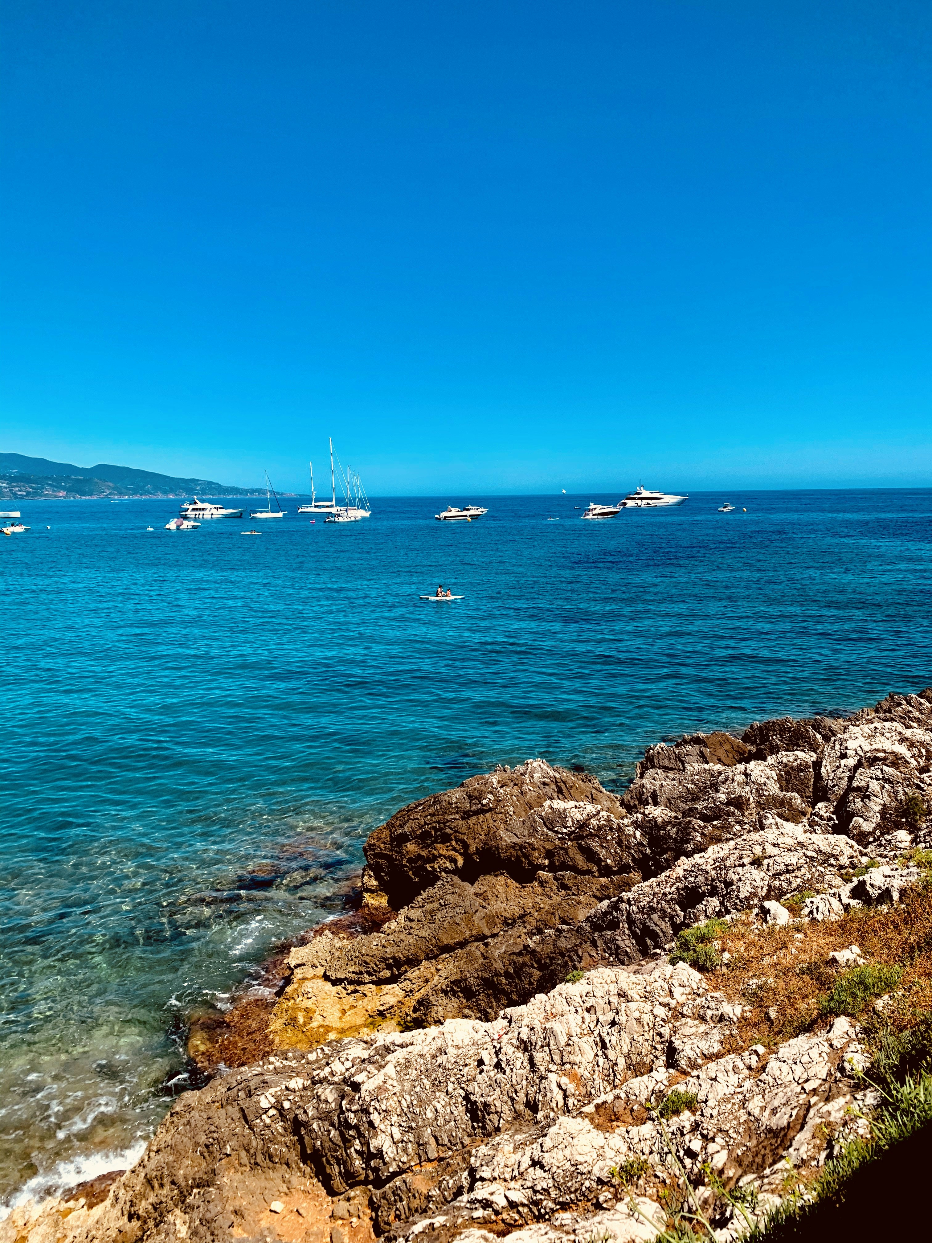 Azure Sails Against a Rugged Littoral