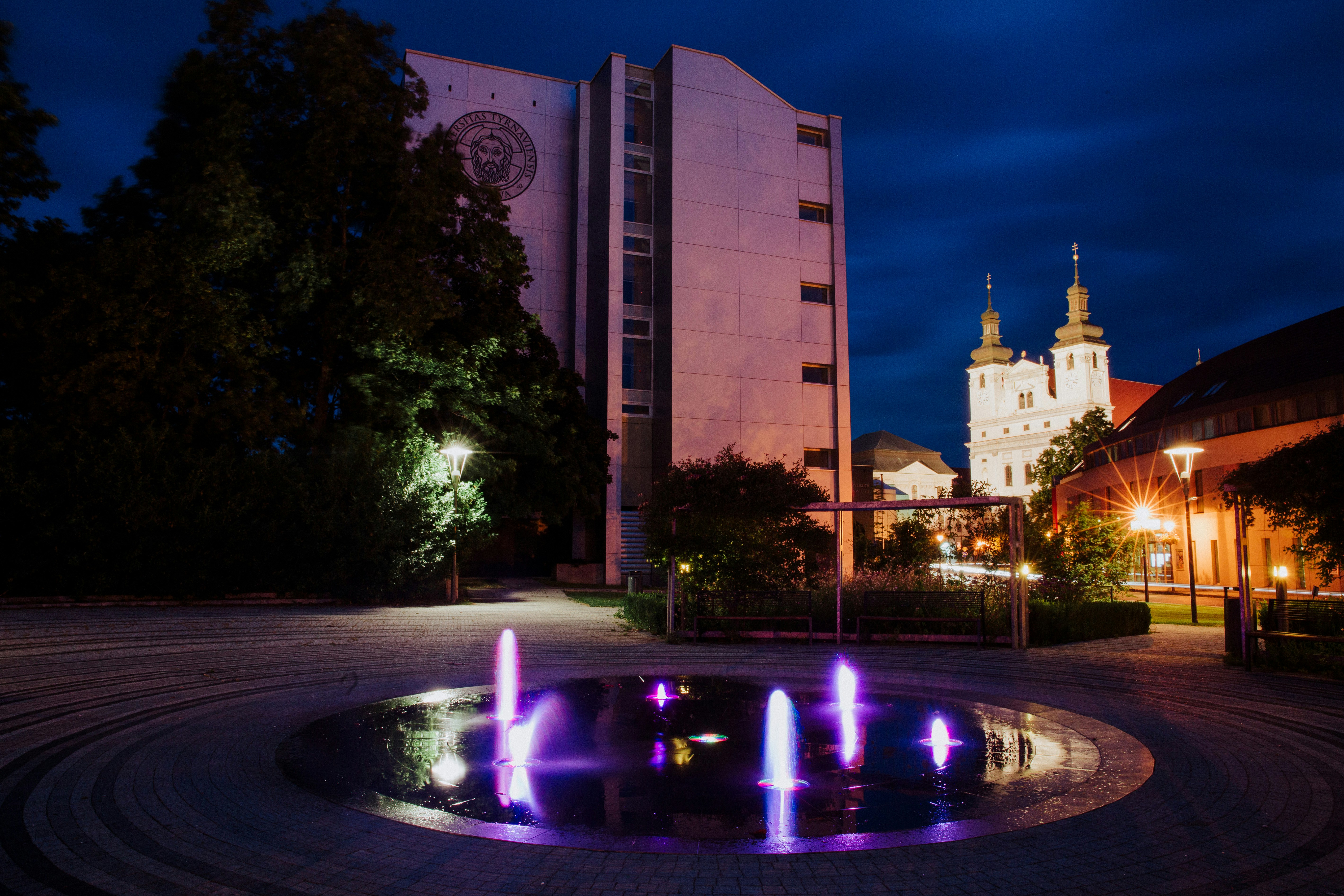 Violet Jets at Dusk: A Quiet City Square Fountain