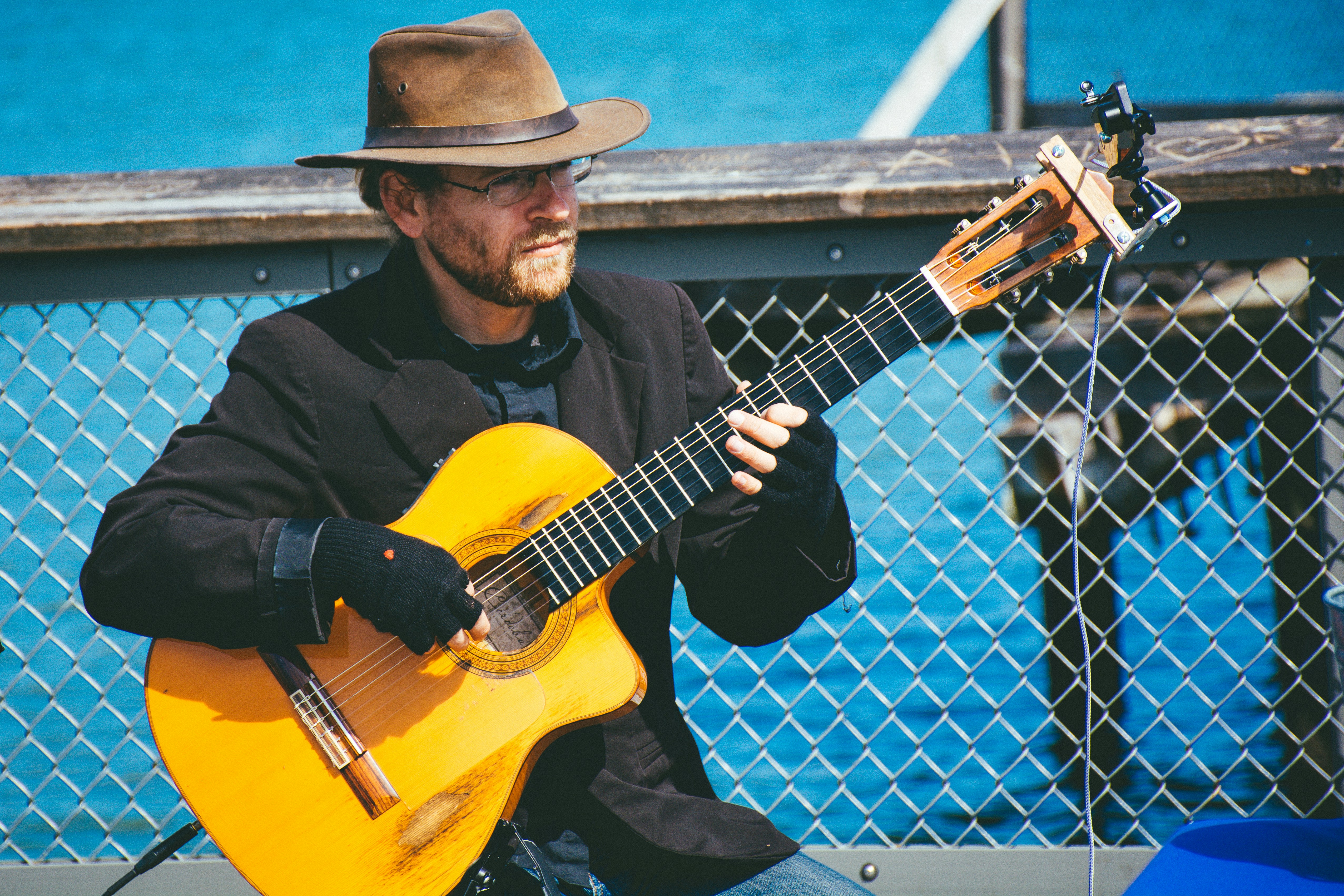 Pier-side Serenade: Sunlit Yellow Acoustic Guitar by the Waterfront
