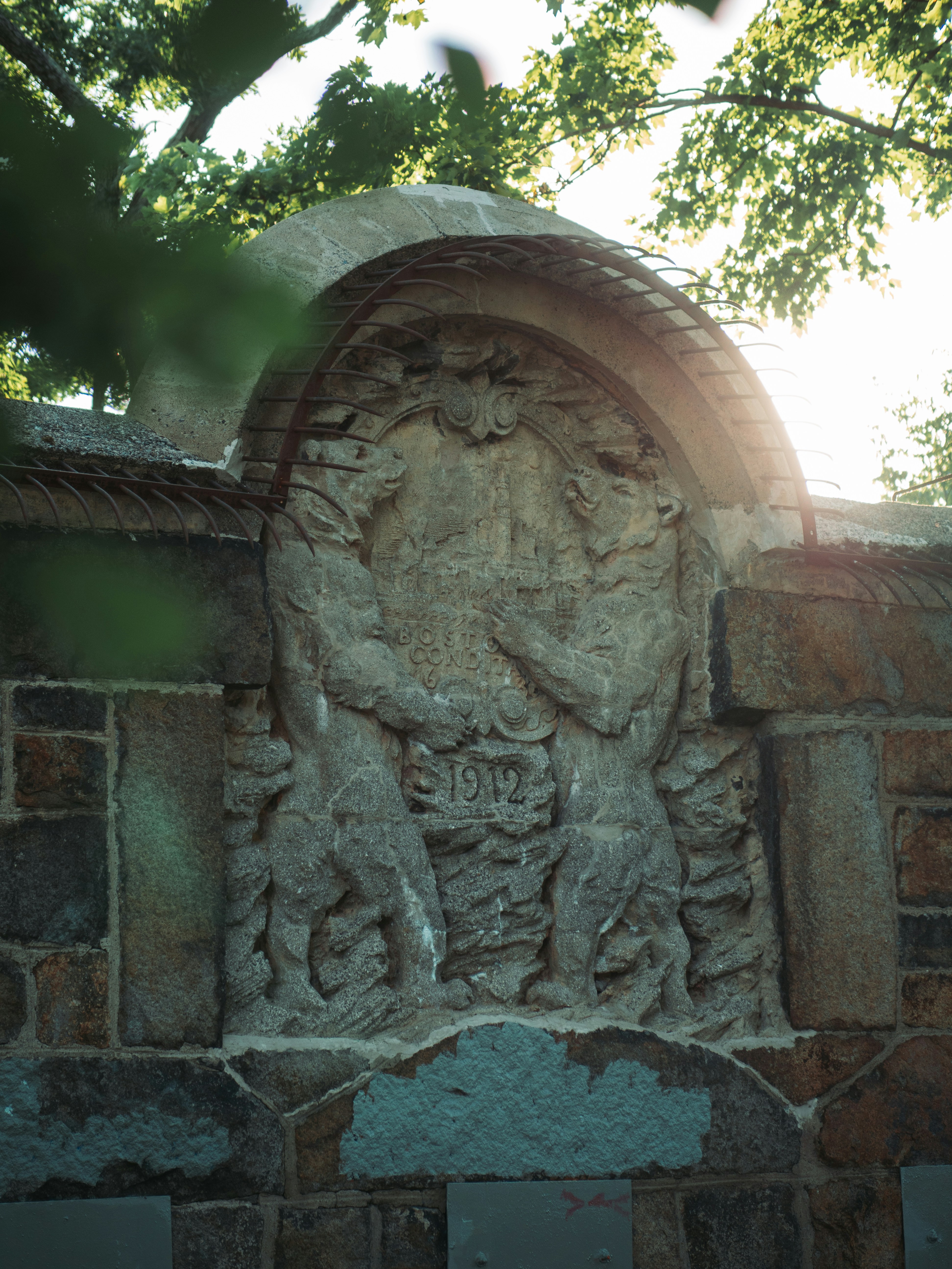 The central crest sculpture of Old Bear Dens in Franklin Park, Boston is surrounded by morning light. 