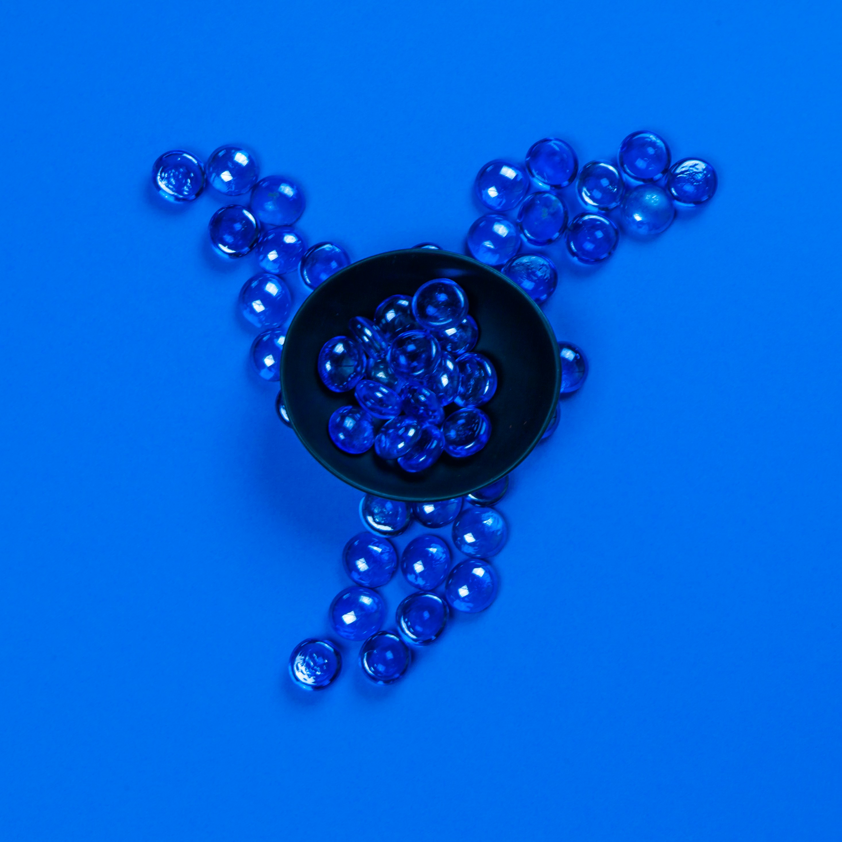 Cerulean Constellation: A Black Cup Cradling Blue Glass Marbles