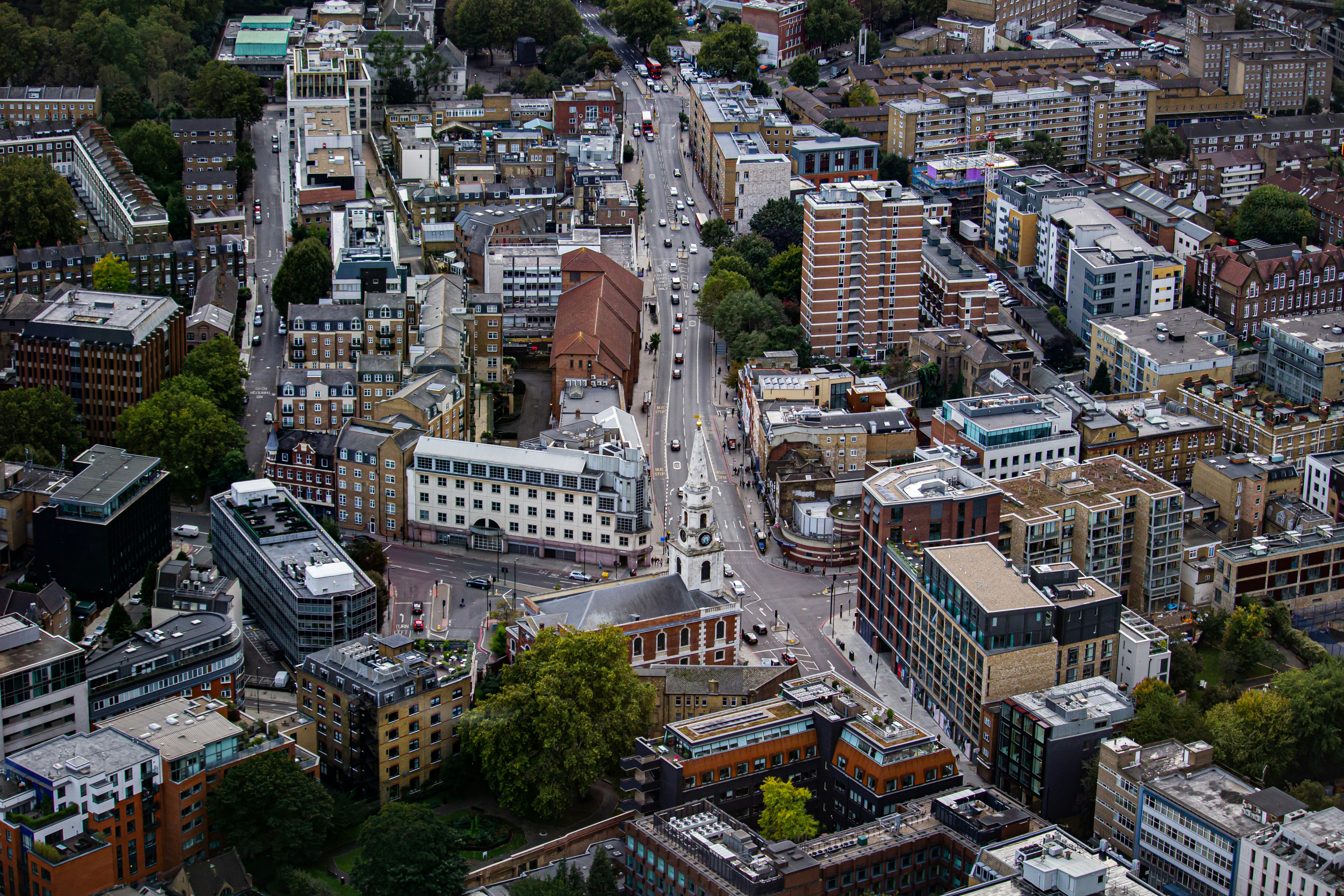 Aerial view showcasing a bustling urban landscape with streets, buildings, and greenery interspersed throughout the city.