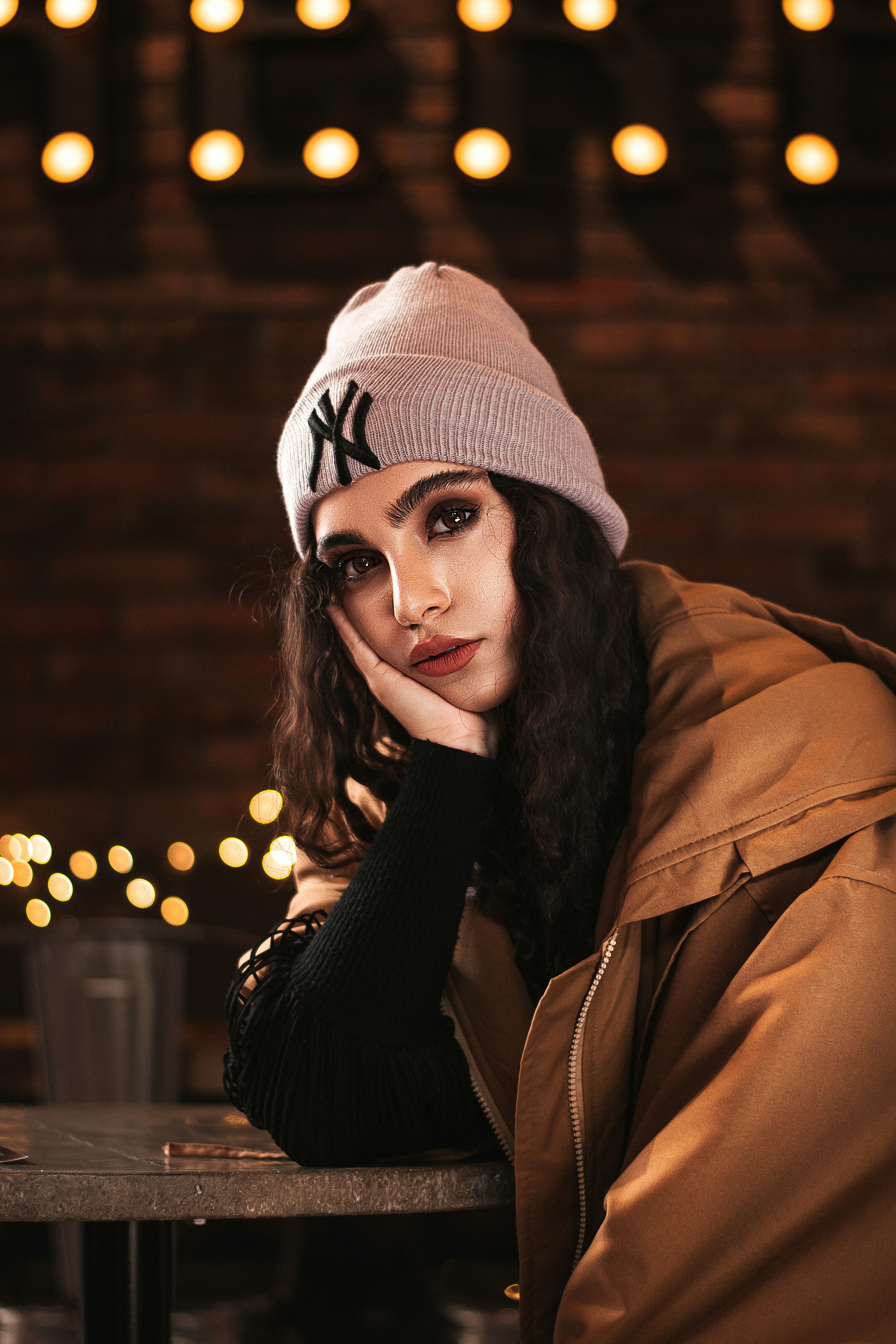 woman in brown jacket and white knit cap