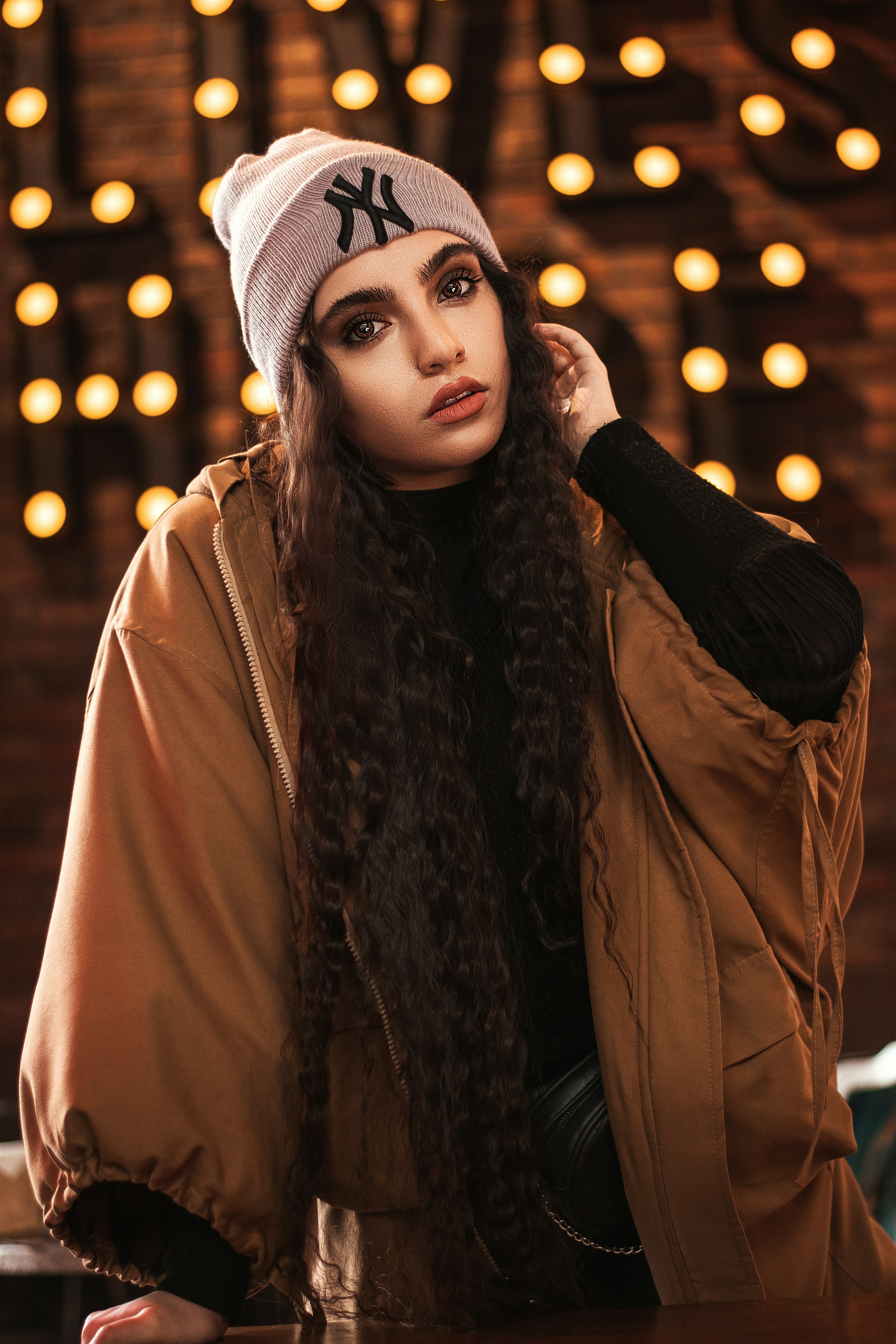 woman in white knit cap and brown coat