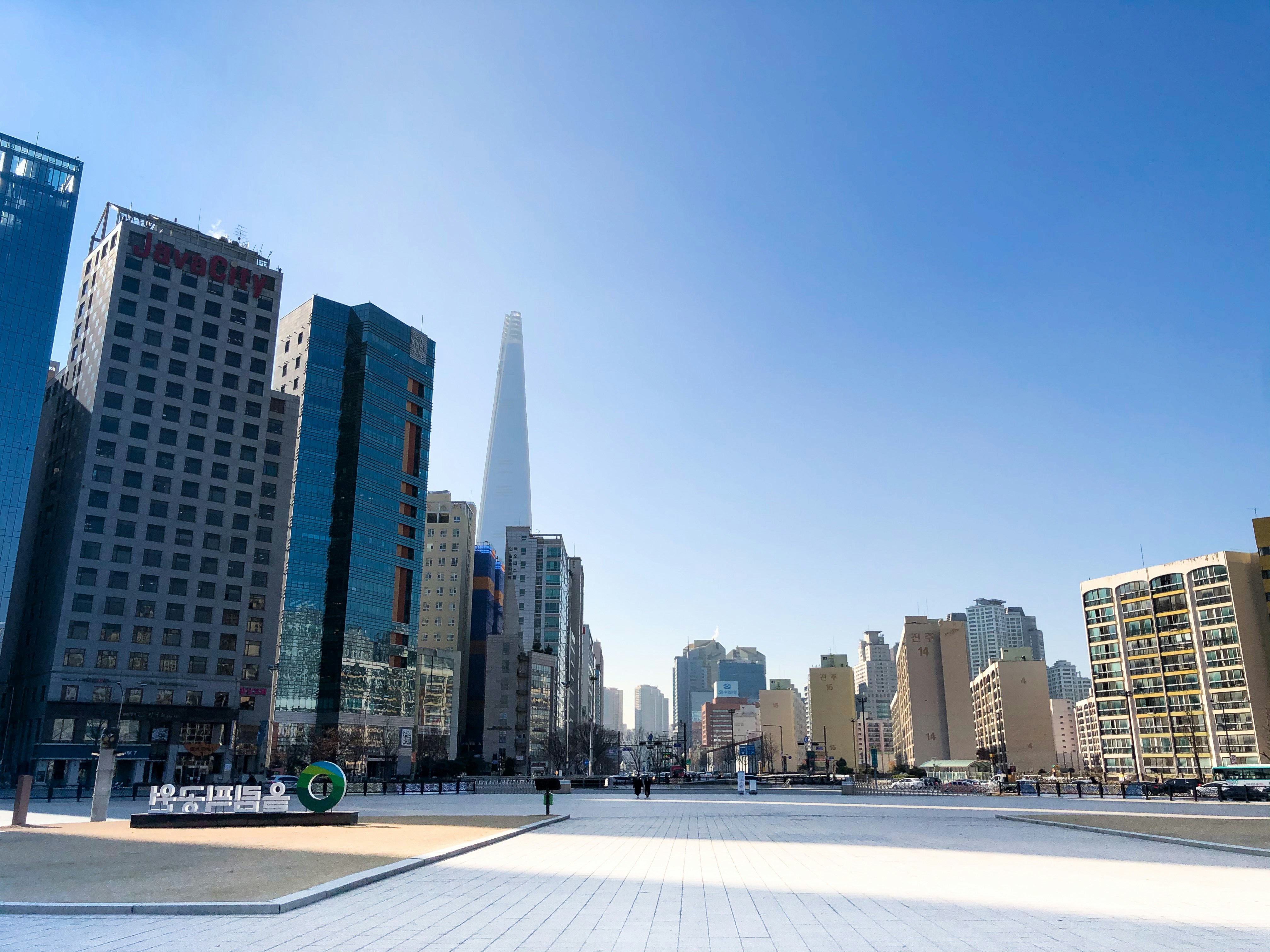 A panoramic view of a bustling city skyline featuring towering skyscrapers under a clear blue sky. The image captures the essence of urban architecture and design.