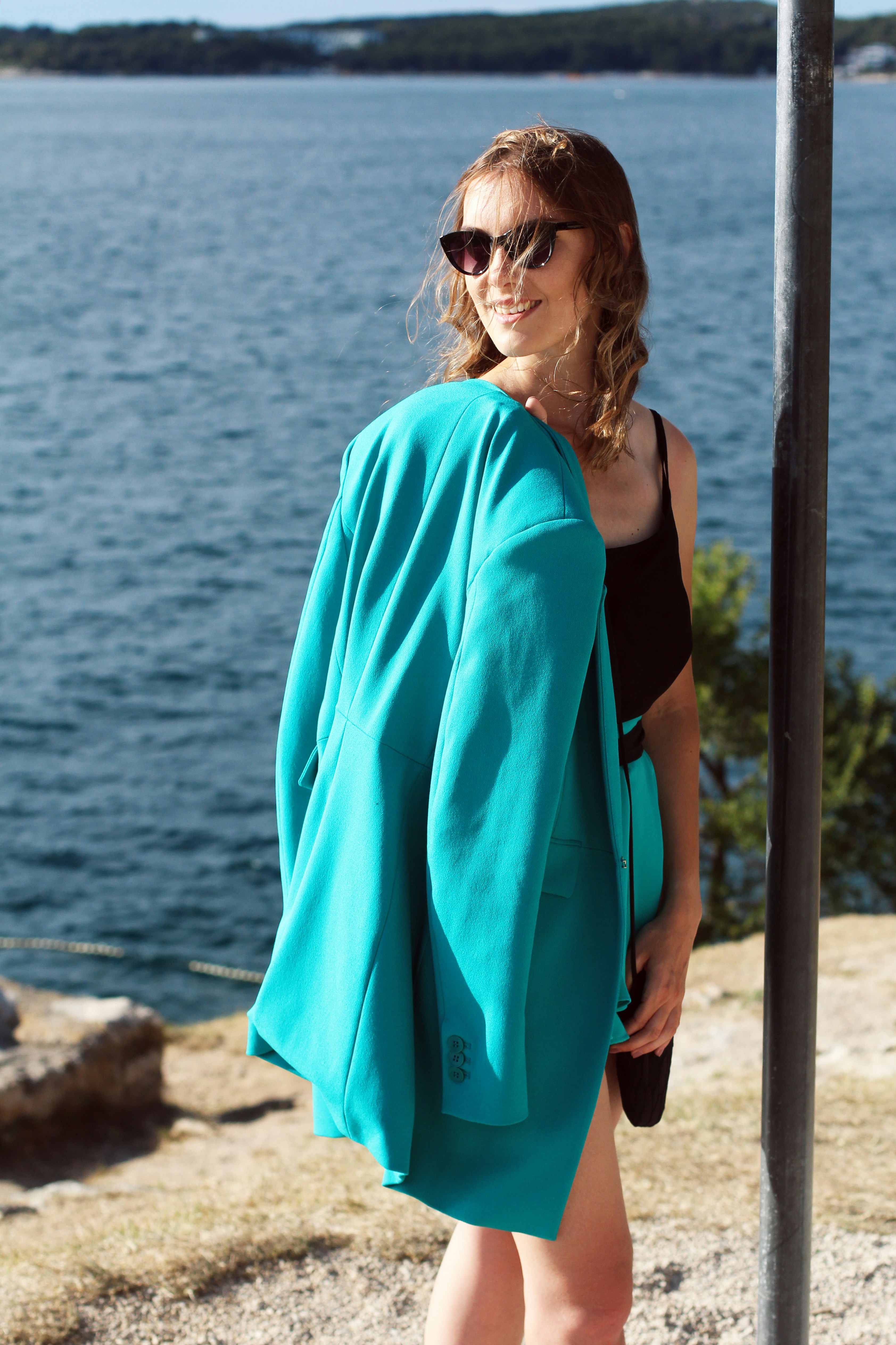Azure Jacket by the Sea: A Sunlit Coastal Portrait