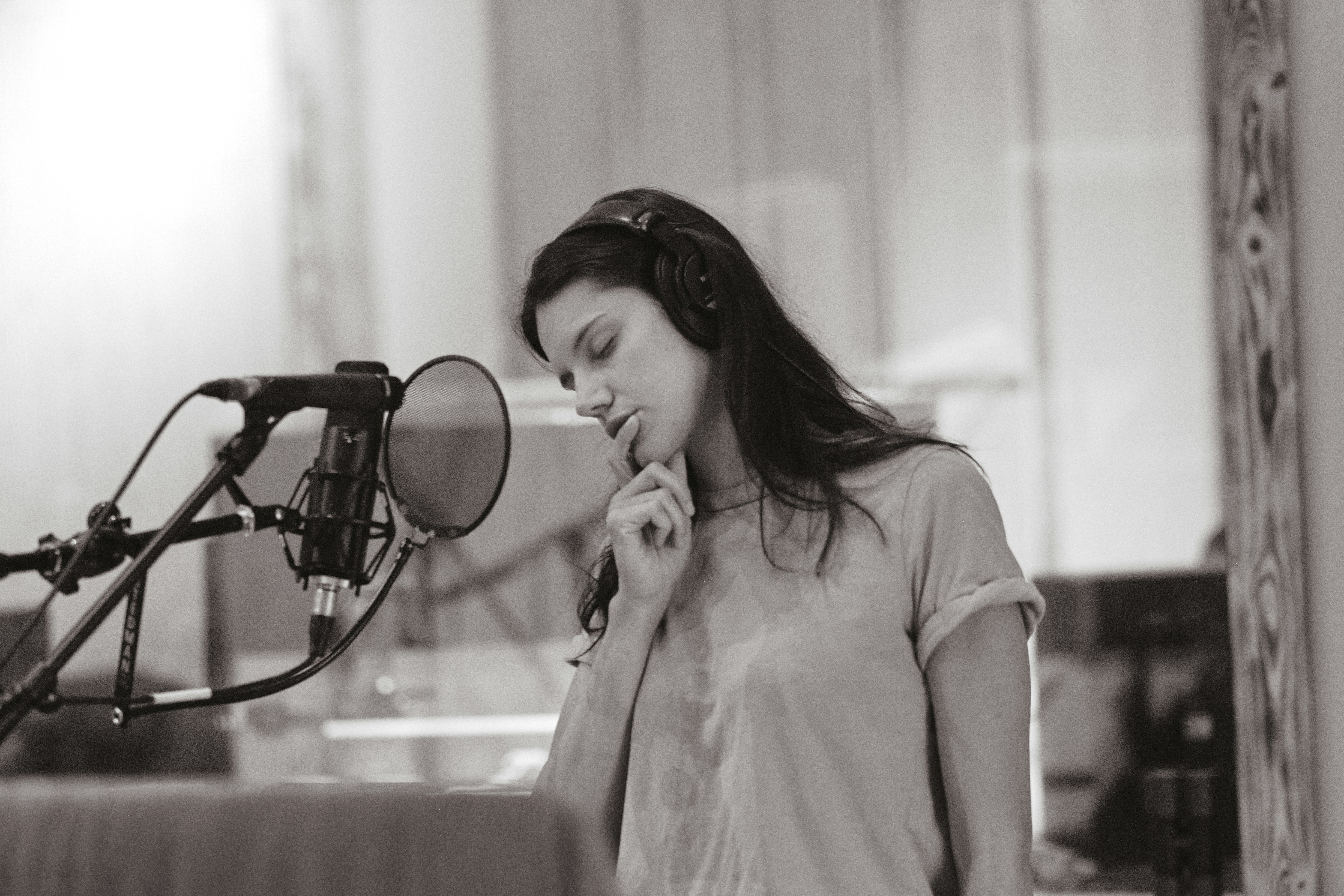 Femme en robe blanche tenant un microphone noir et argent photo – Image ...