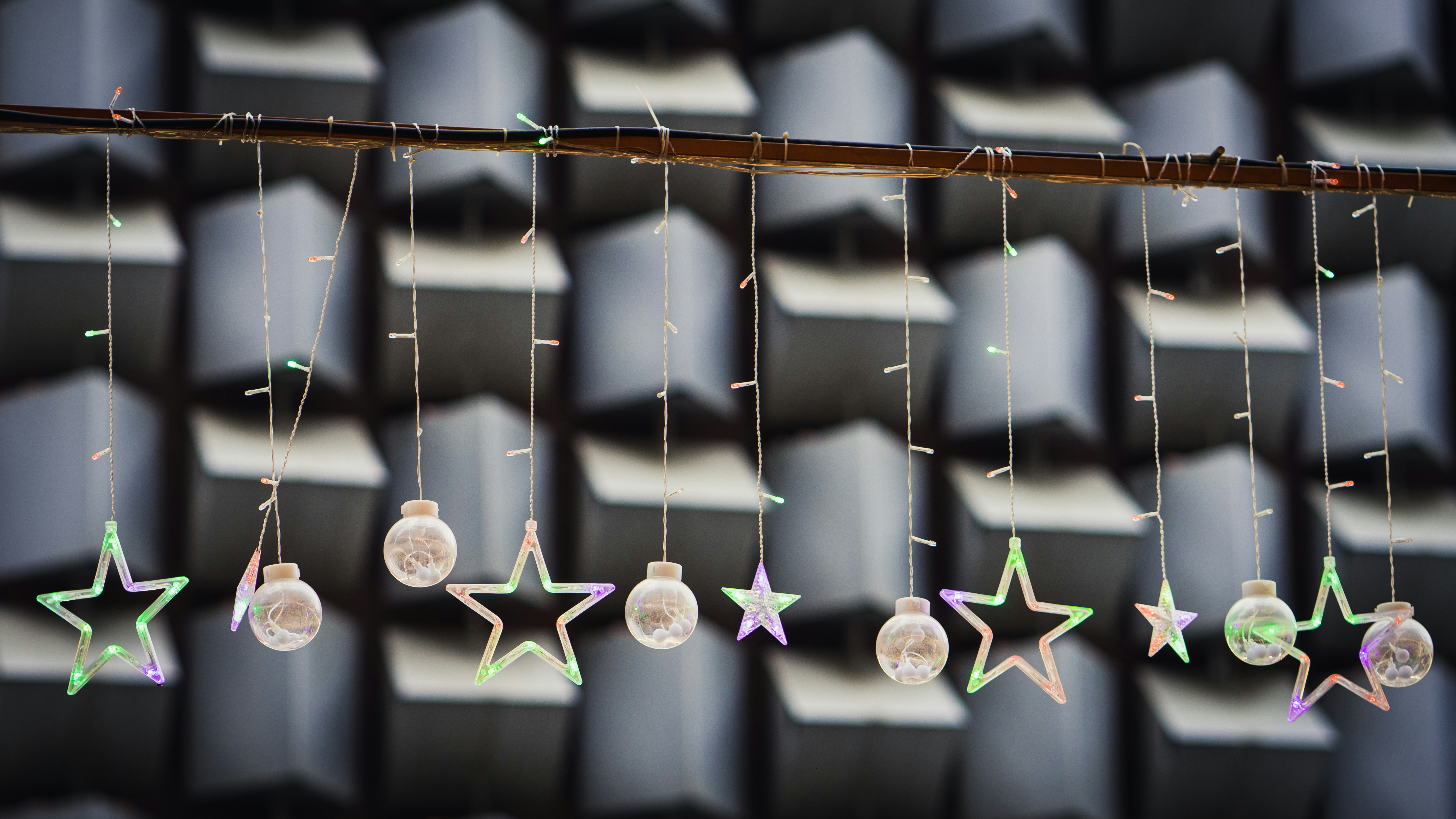Pastel Star Garland: Delicate Ornaments in a Soft Blur Over Dark Seating