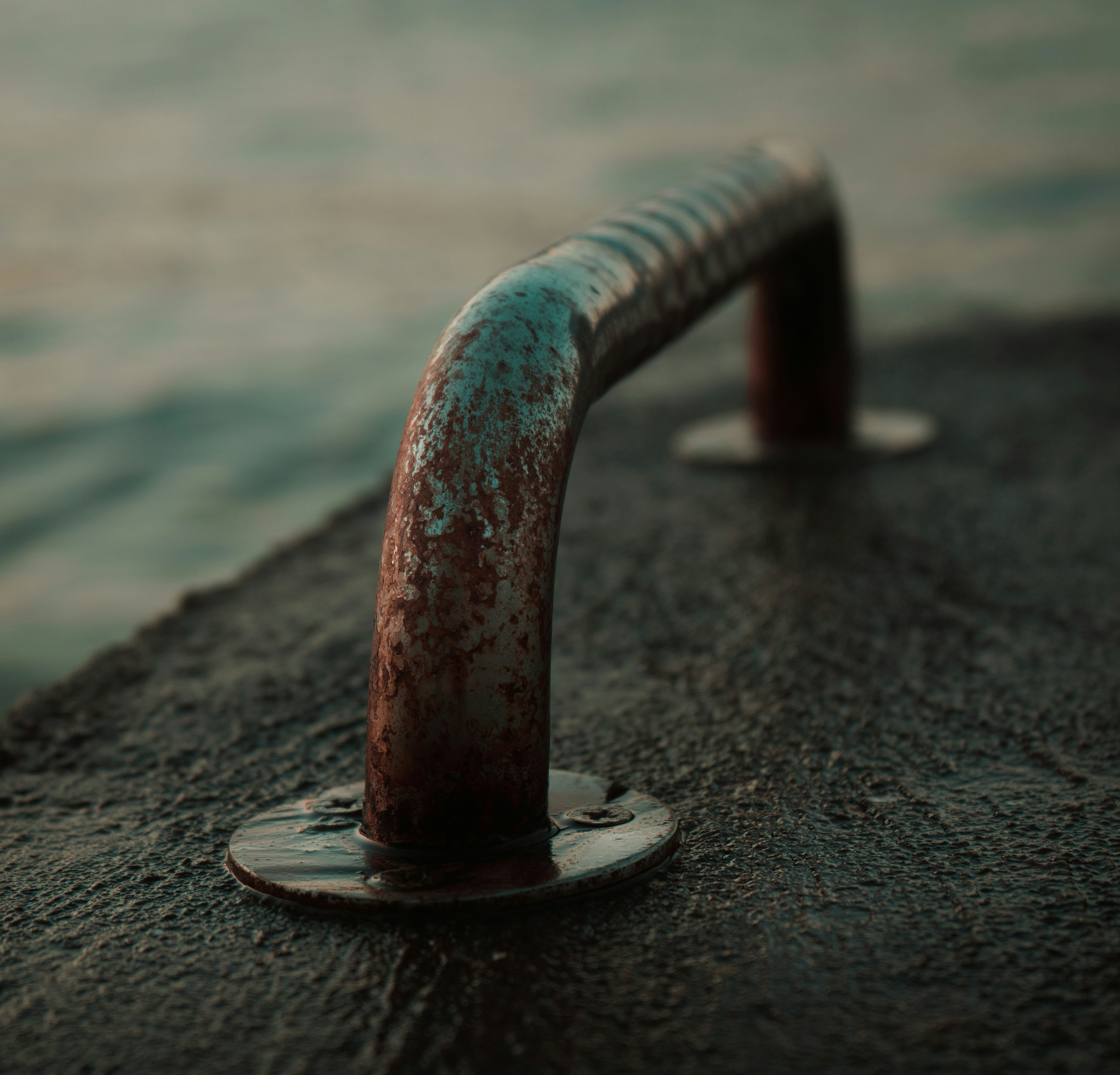 Patina on the Pier: A Close-Up of a Rusted Rail Embracing the Sea