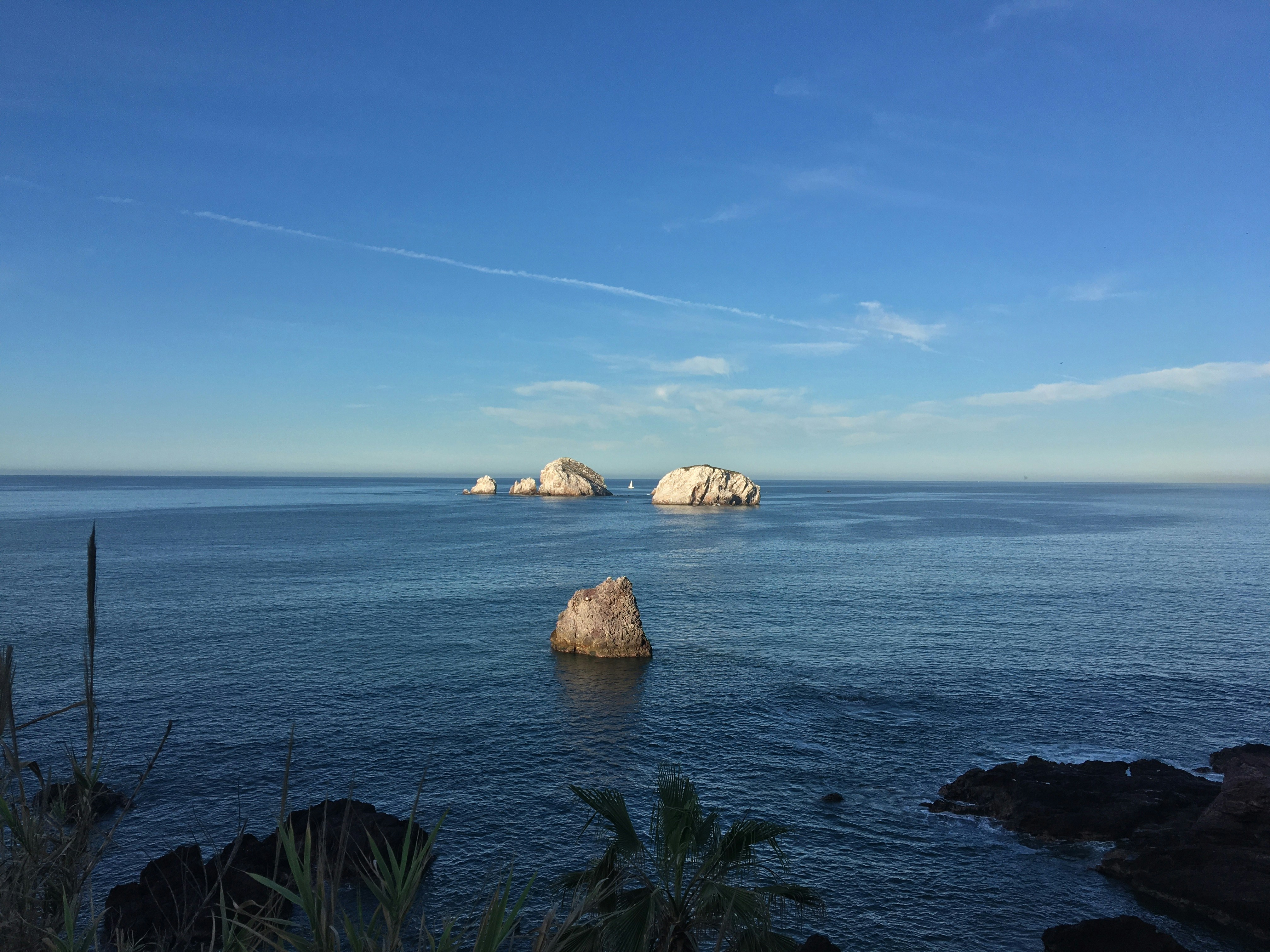 Foto Formación de roca marrón en el mar bajo un cielo azul durante el ...