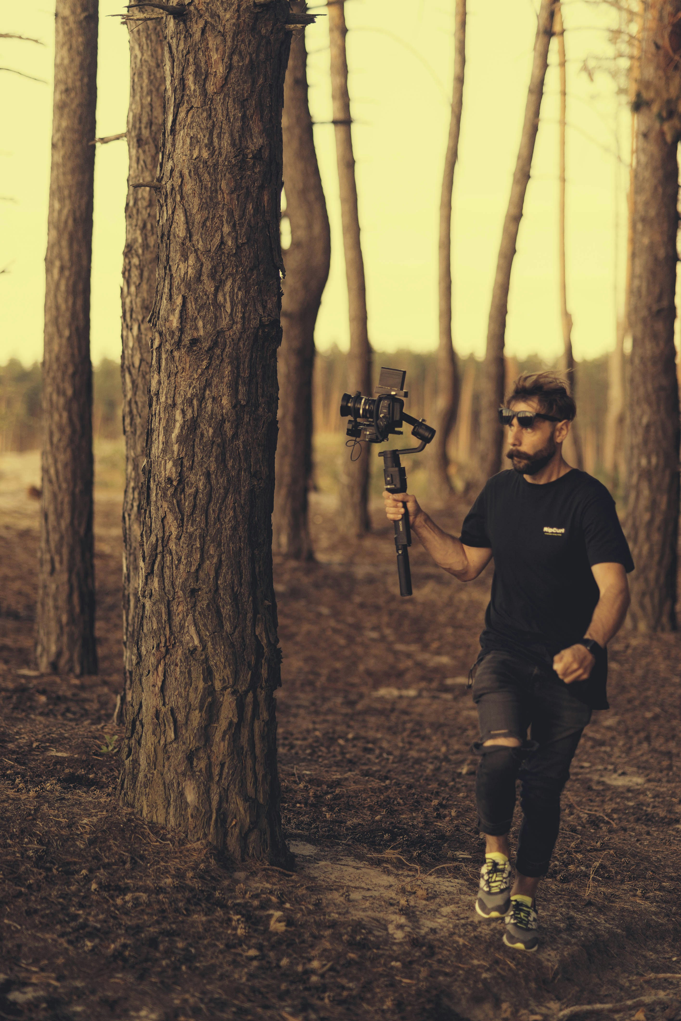 man in black crew neck t-shirt holding black camera