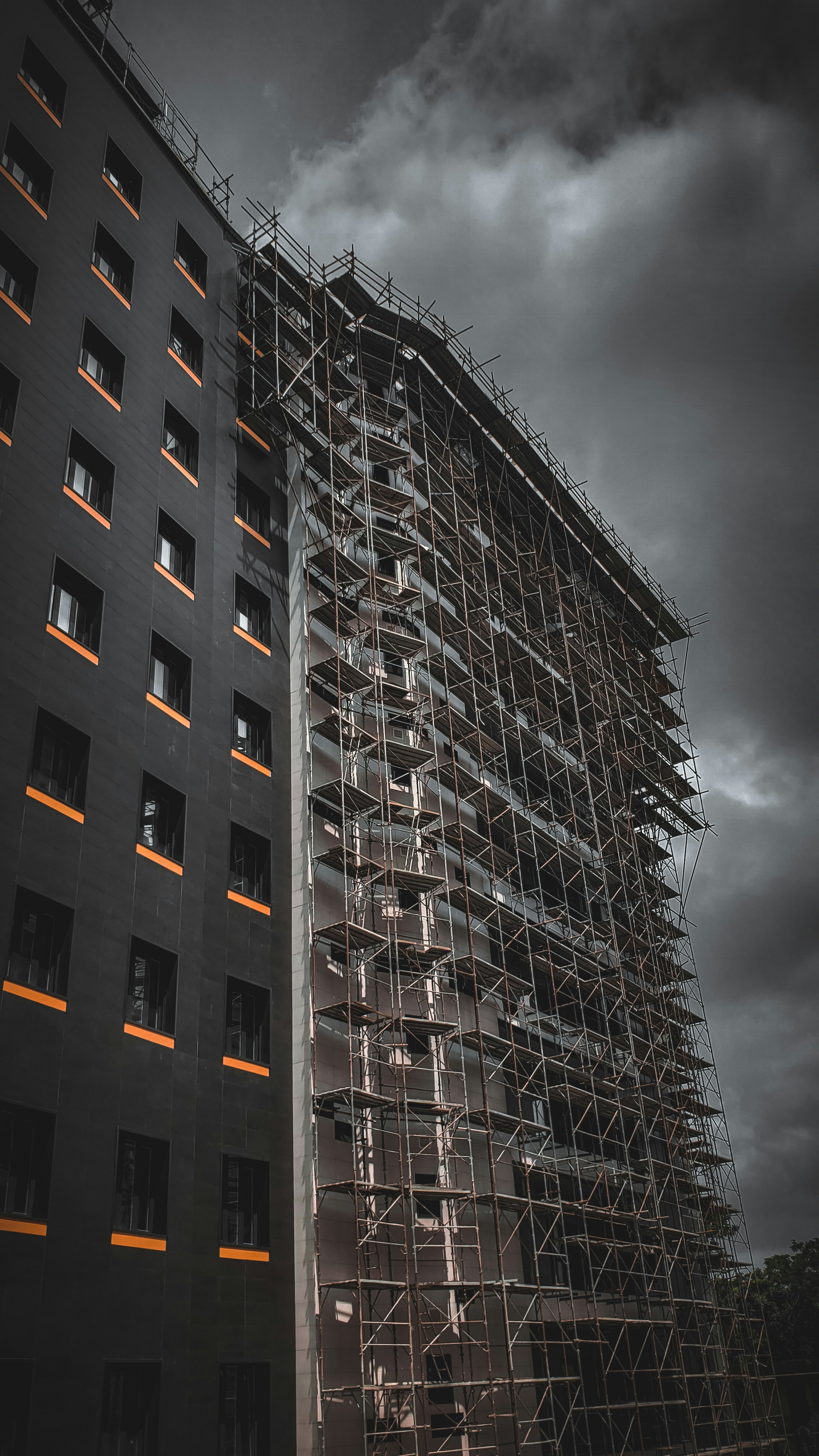 Midnight Framework: Scaffolding Rising Against a Stormy City Edge