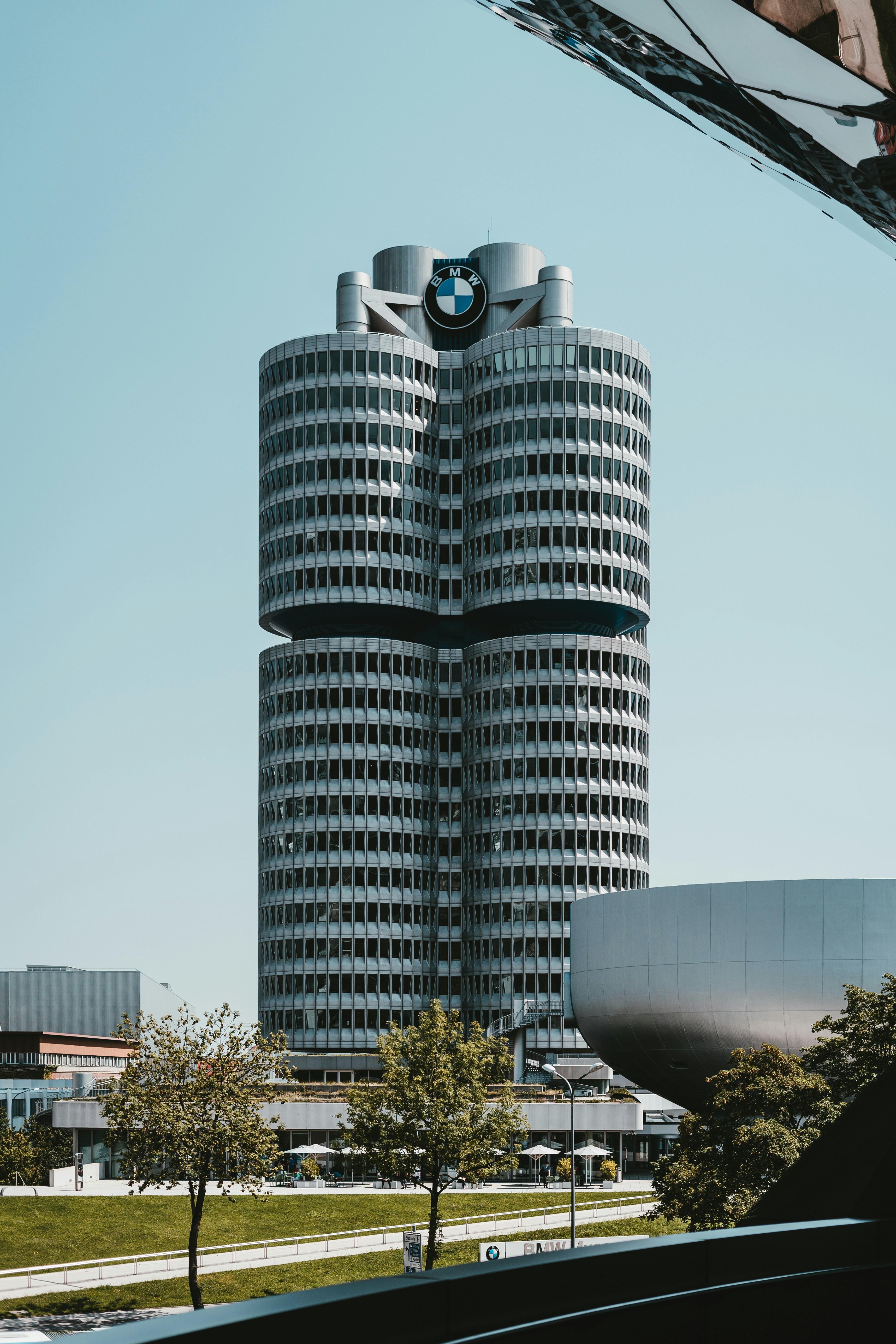 Iconic BMW headquarters building featuring a distinct cylindrical design against a clear blue sky.