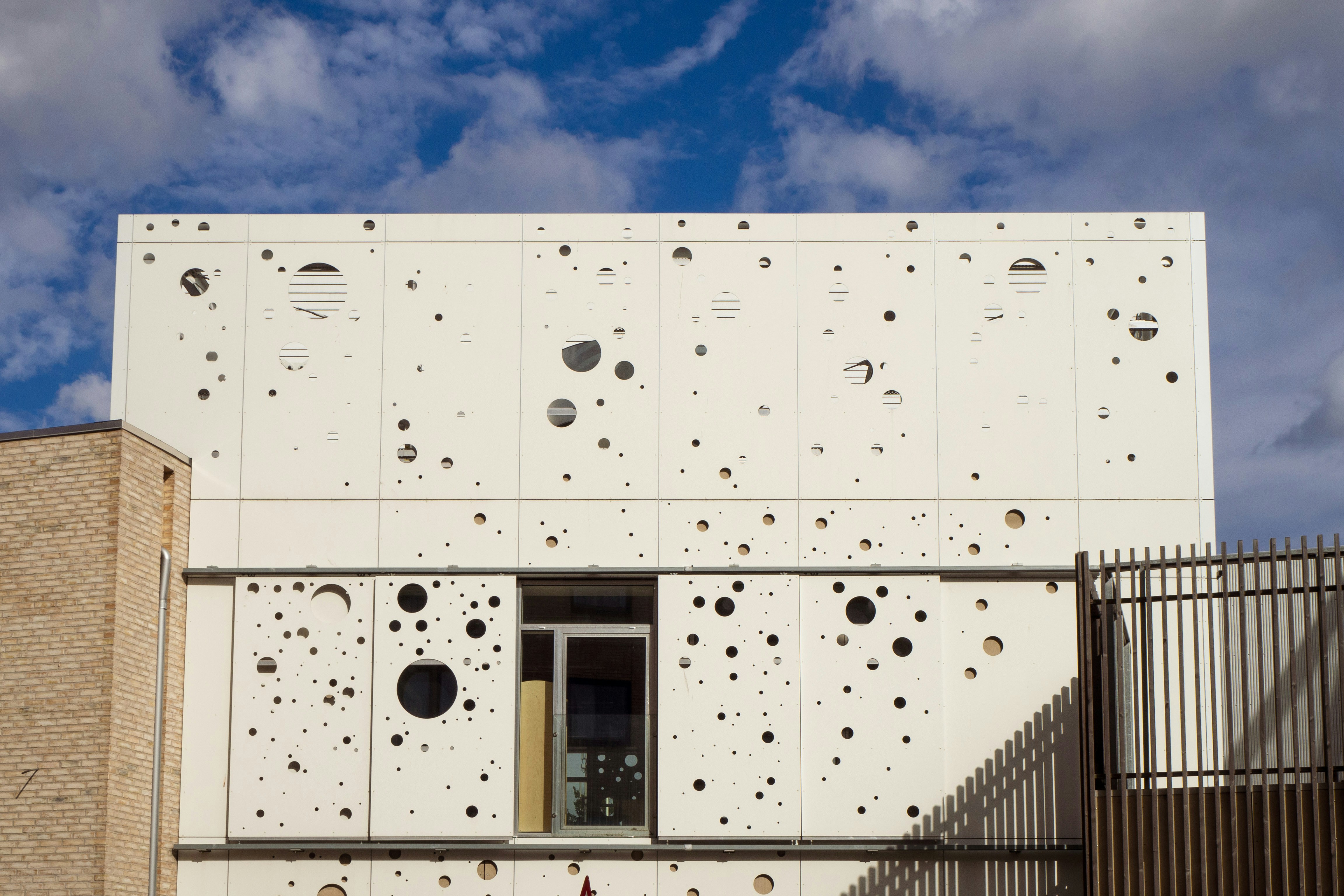 A building with holes on the side of it photo – Free Copenhagen Image ...