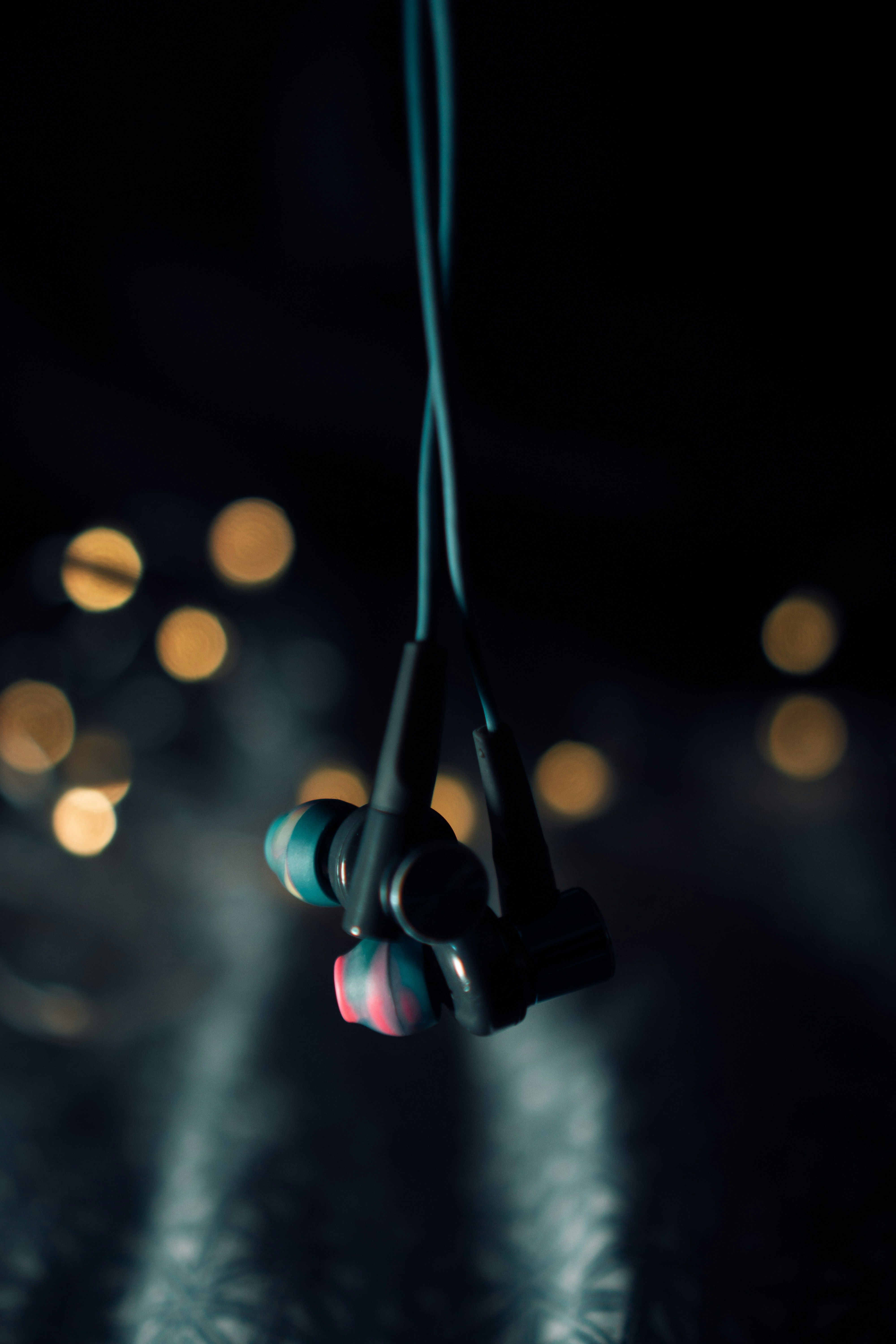 Hanging Echoes: A Stranded Pair of Earbuds in Night’s Blur