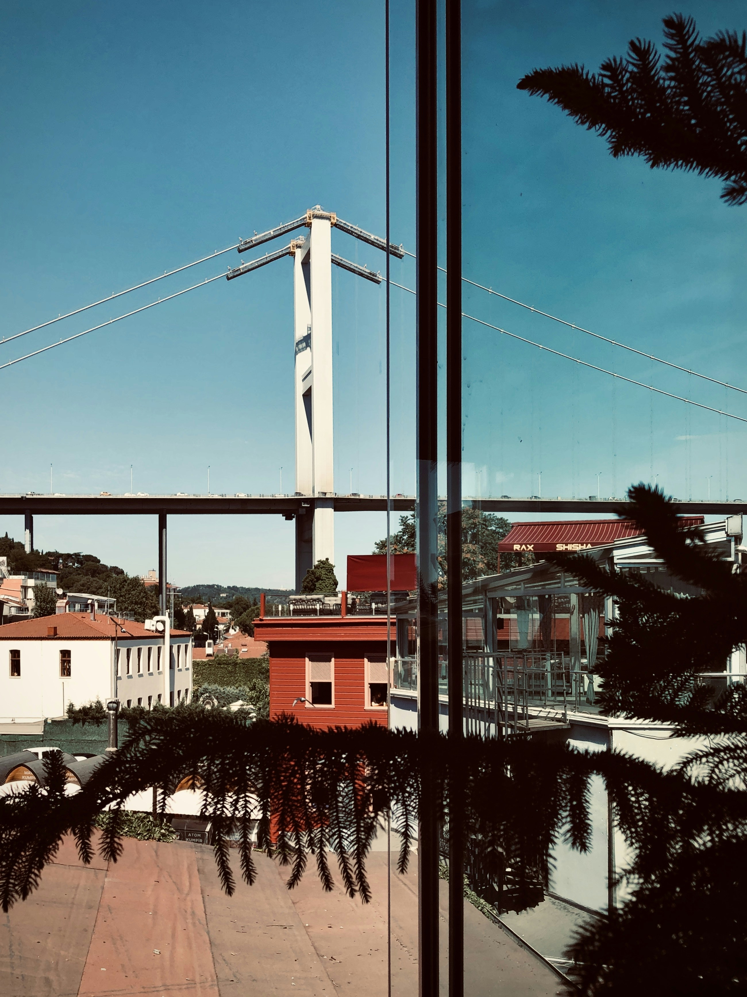 White and brown concrete building near bridge under blue sky during ...