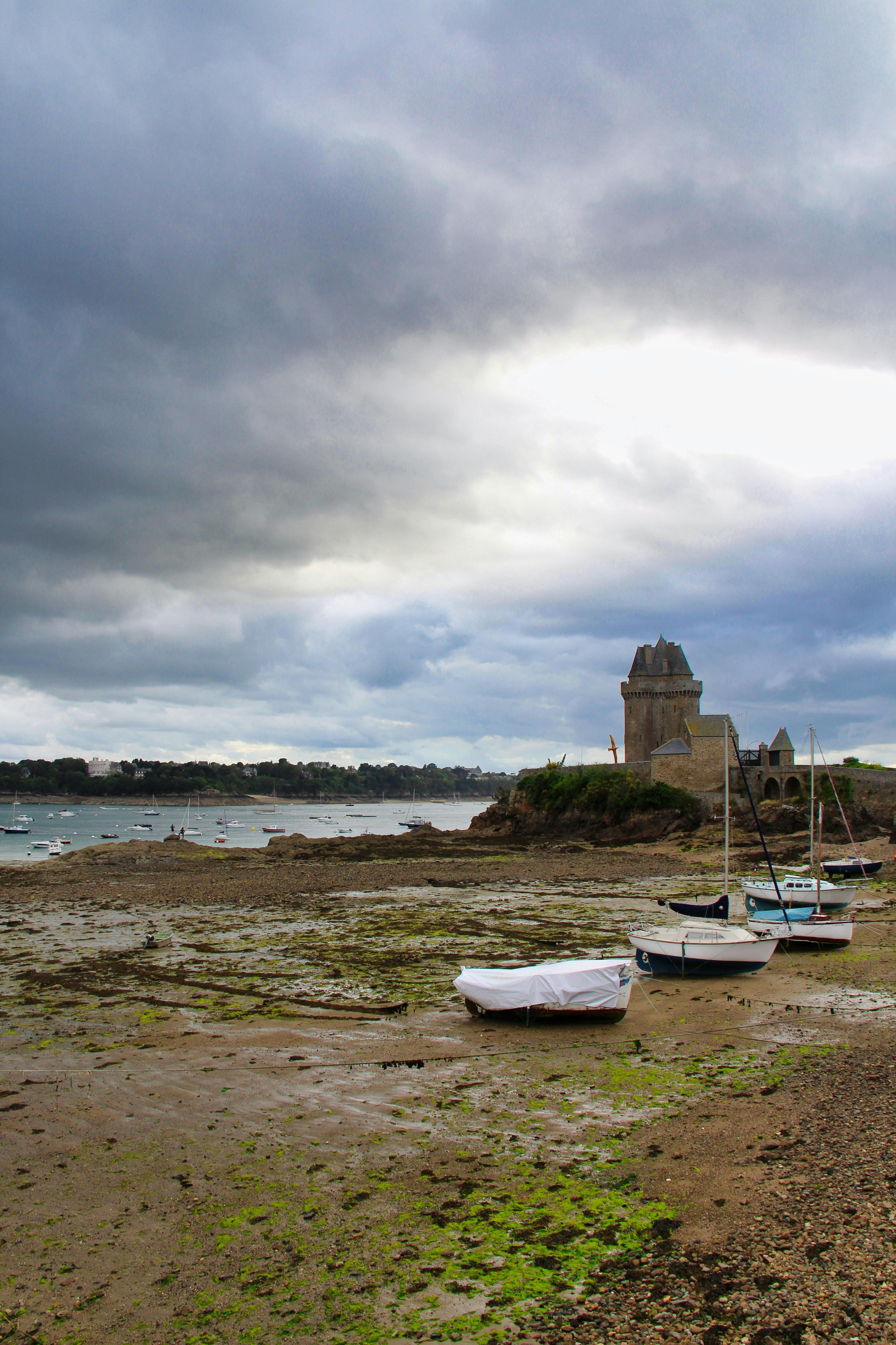 Coastal ruins at dusk: boats ashore as stormy clouds gather