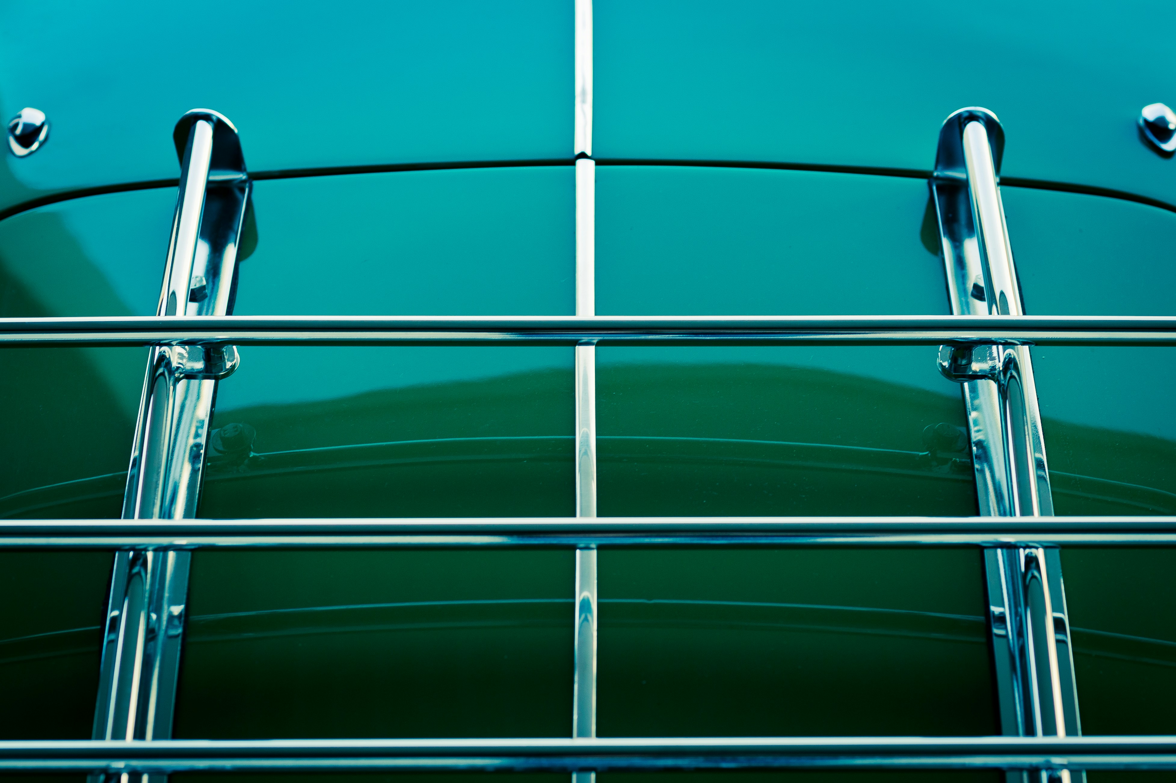 Teal Chrome Ribs: A Close-Up of a Vintage Car Grille