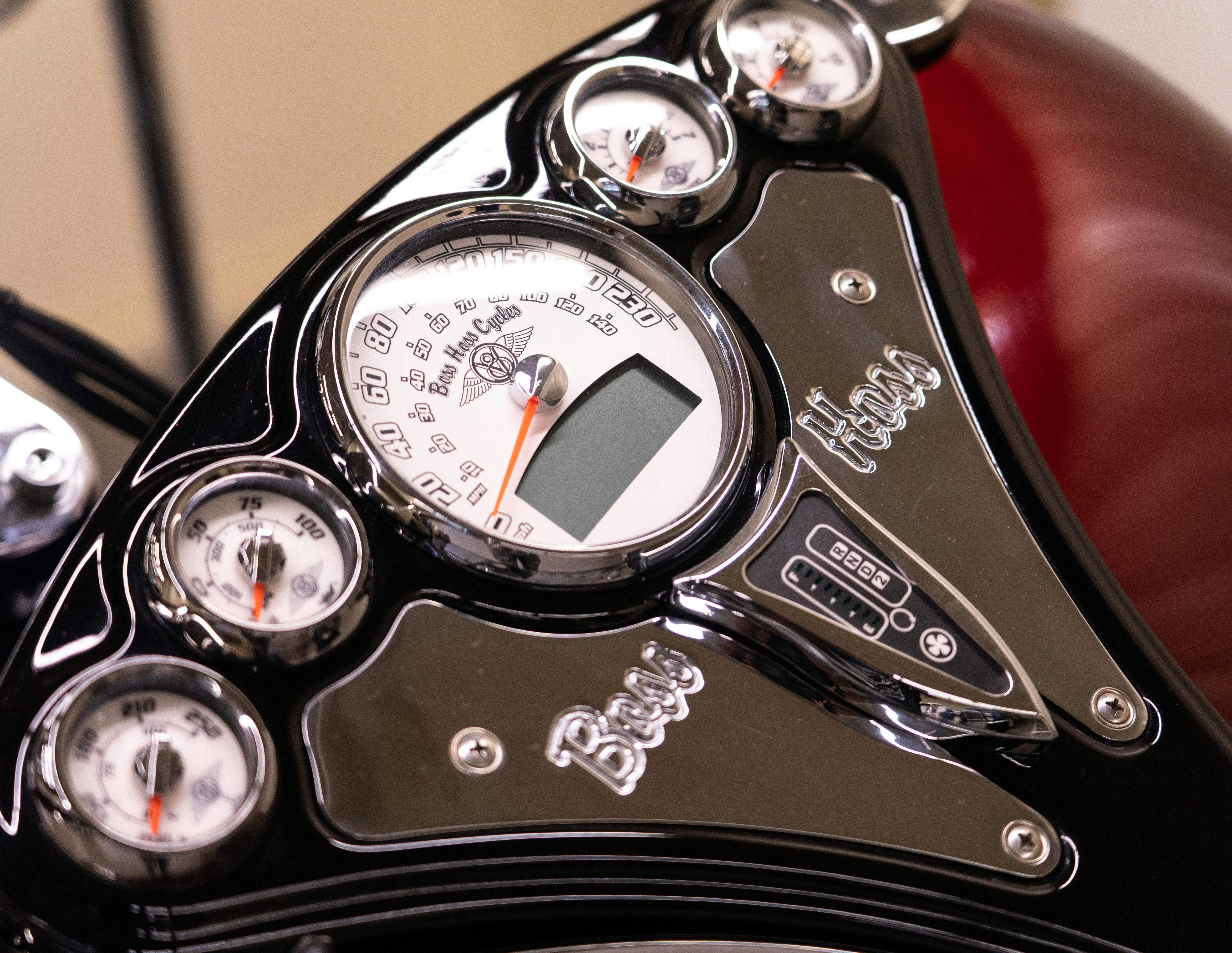 Close-up of a motorcycle dashboard featuring gauges and a digital display, showcasing intricate design and functionality.
