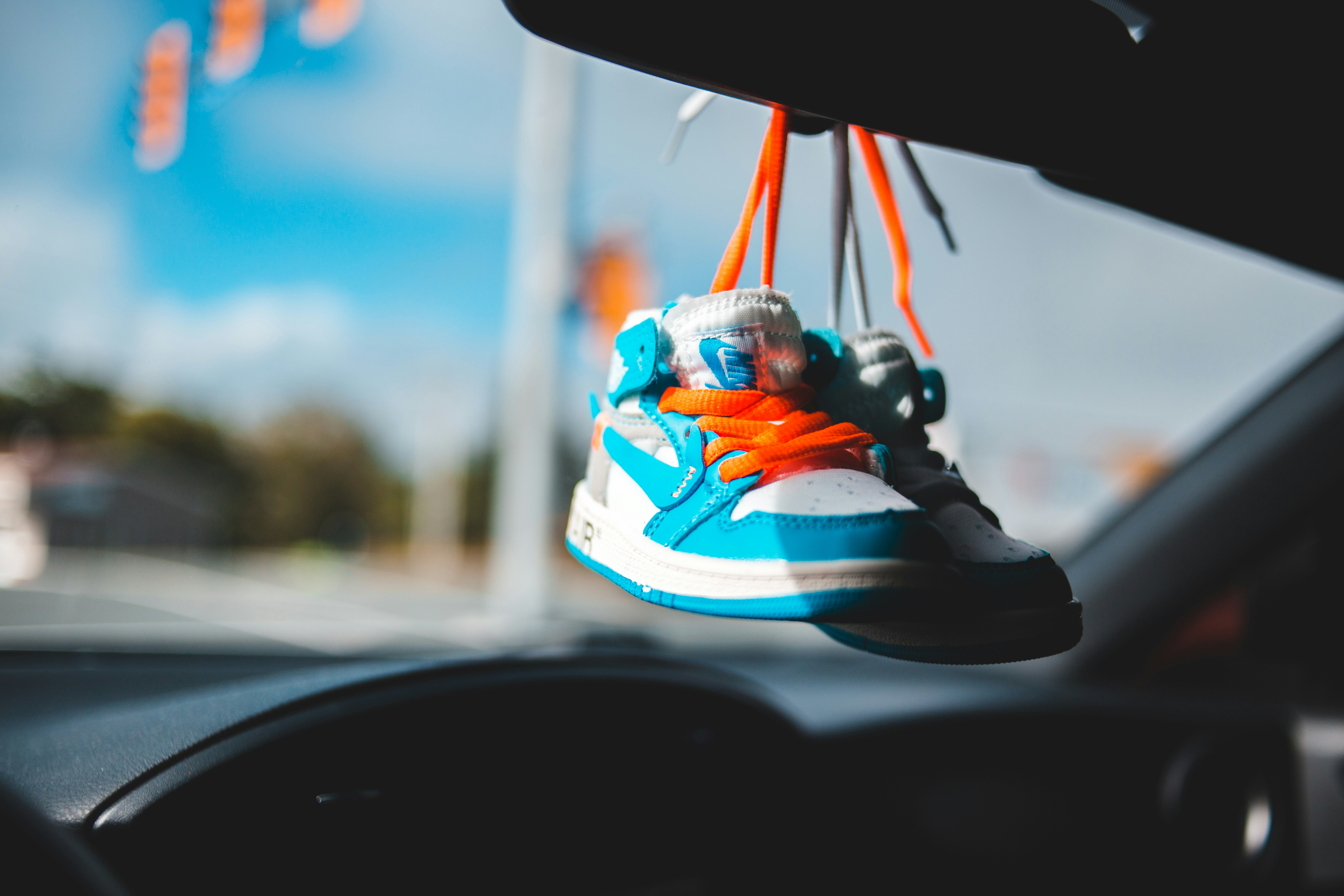 Tiny Blue Sneakers Suspended in a Car's Quiet Morning Light
