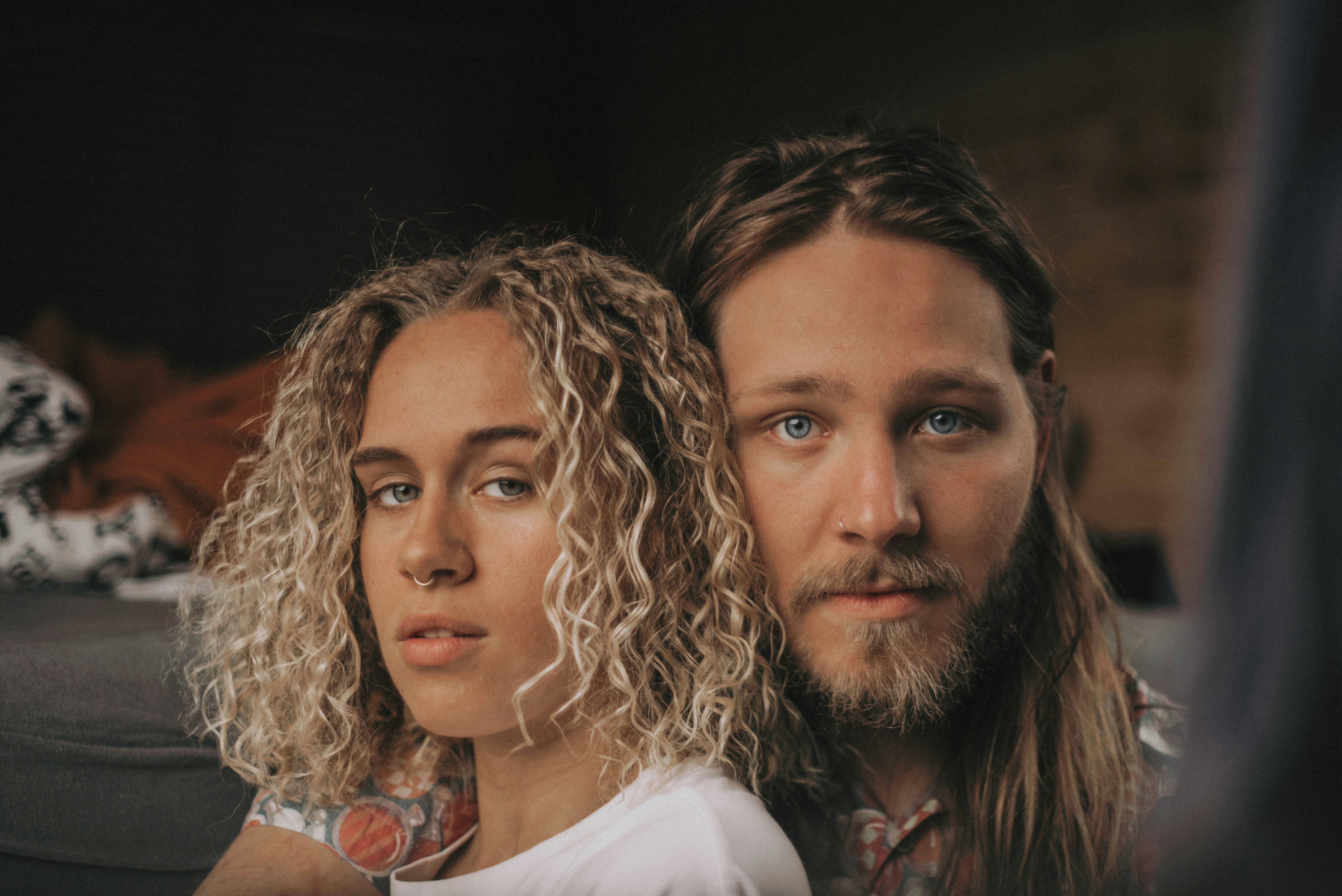 Two individuals sharing a close moment, with soft natural light highlighting their features and expressions.